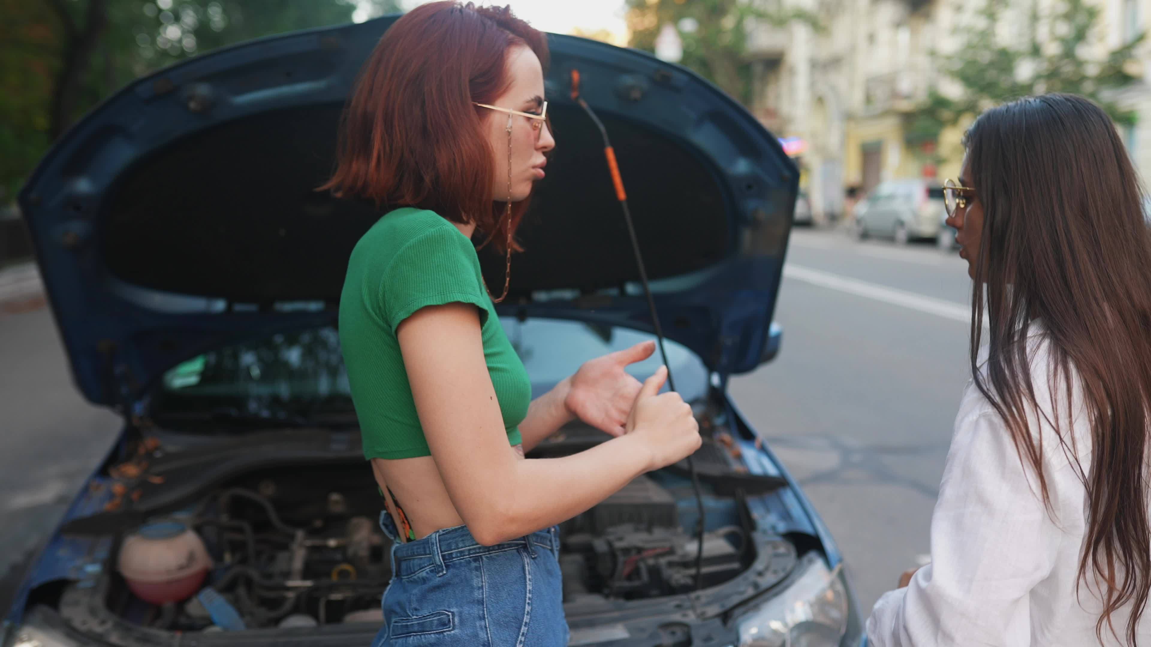 Two young women look under the hood of a car 13105897 Stock Video at ...