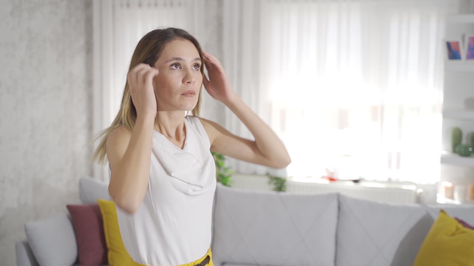 Young woman scared and worried inside the house in slow motion. Young woman looks around in ...