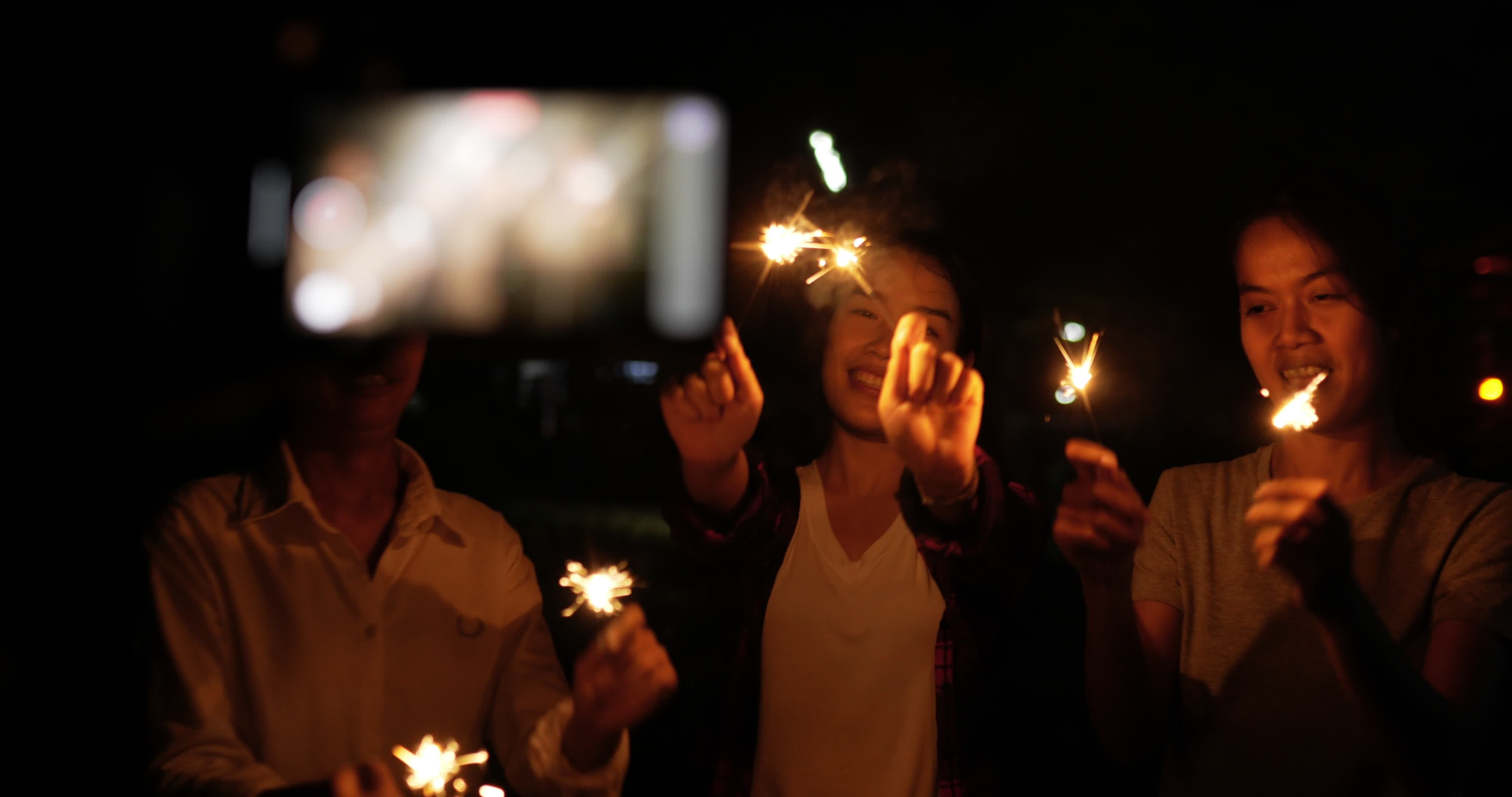 Selective focus, Group of female teenager holding fireworks burning sparklers, Blurred the video ...
