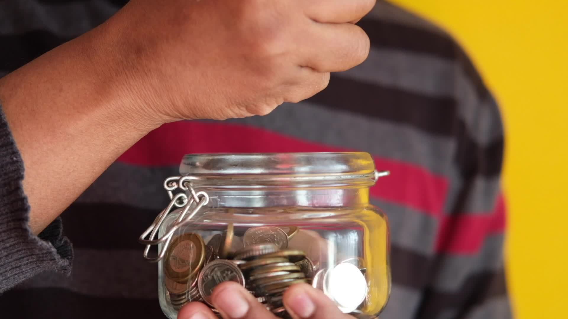 Adding money to a glass savings jar with coins inside 15808029 Stock ... Adding money to a glass savings jar with coins inside 15808029 Stock ...