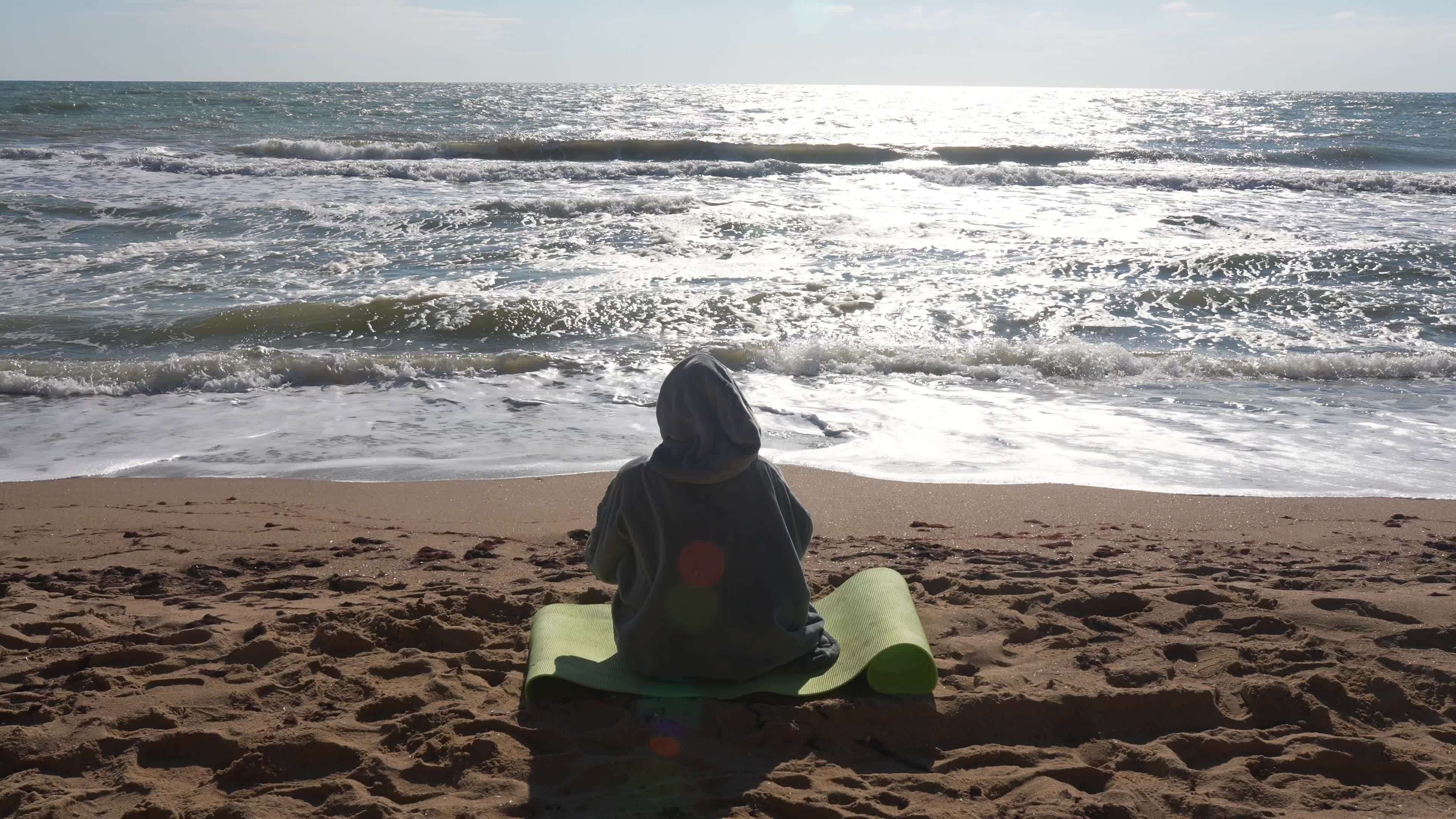 Person seated on a beach watching the waves 16091124 Stock Video at ...