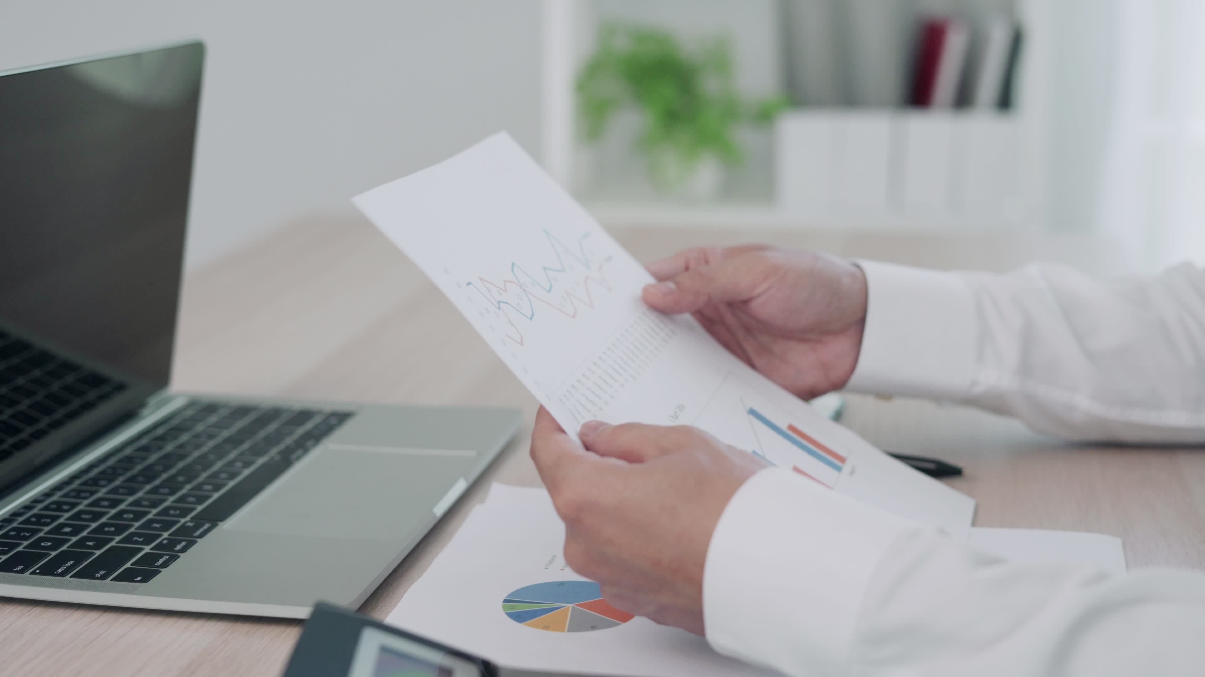 Business men looking at charts, spreadsheets, graph financial ...