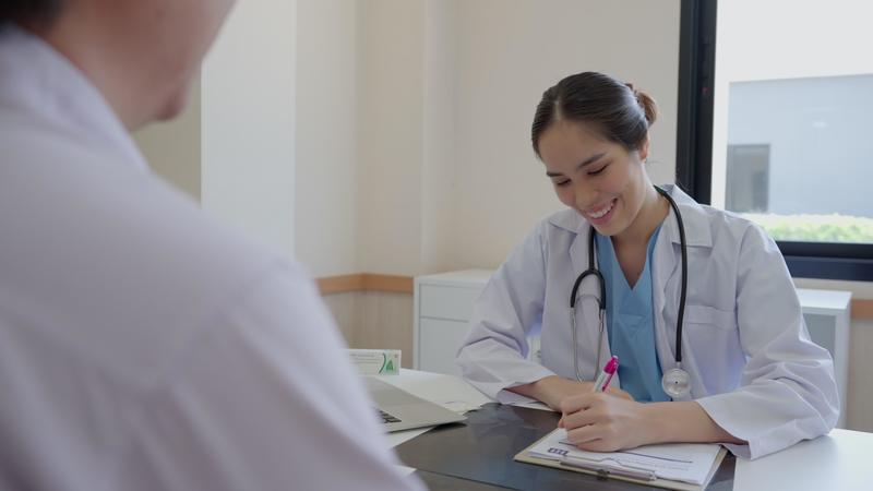 Asian woman doctor interviews and records the patient's health for set program treatment.The ...