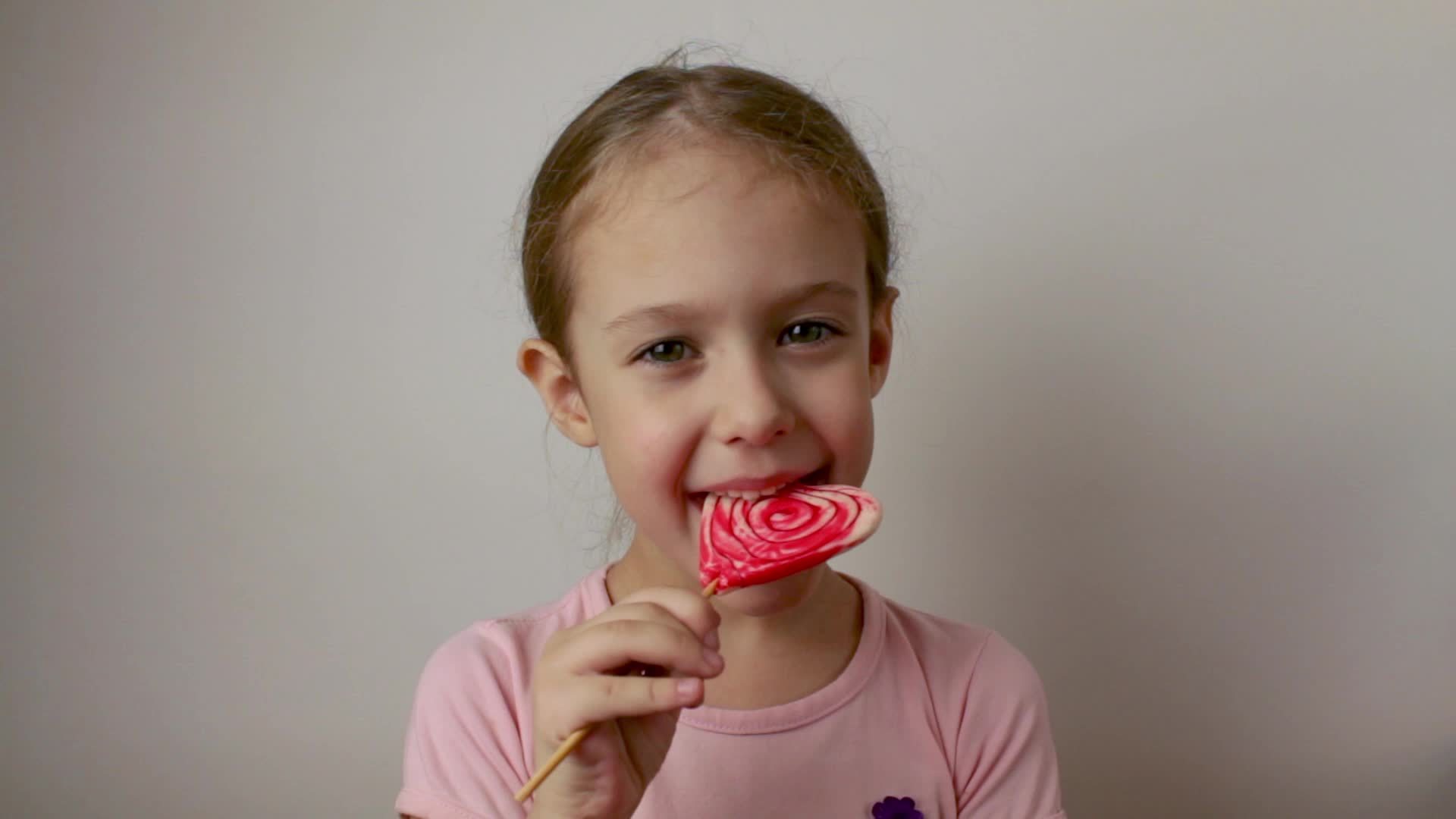 A Cute Girl Sucks A Big Red Lollipop Isolated White Background