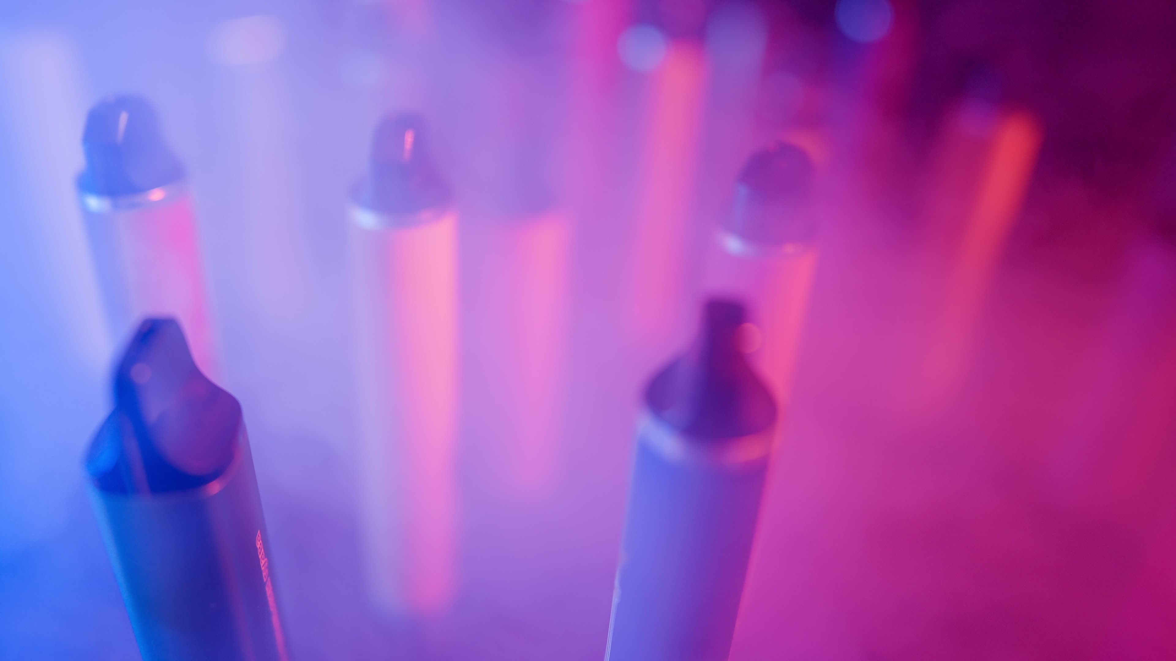 Lots Of E cigarettes And Vapes In Neon Lighting And Smoke Concept Of lots-of-e-cigarettes-and-vapes-in-neon-lighting-and-smoke-concept-of
