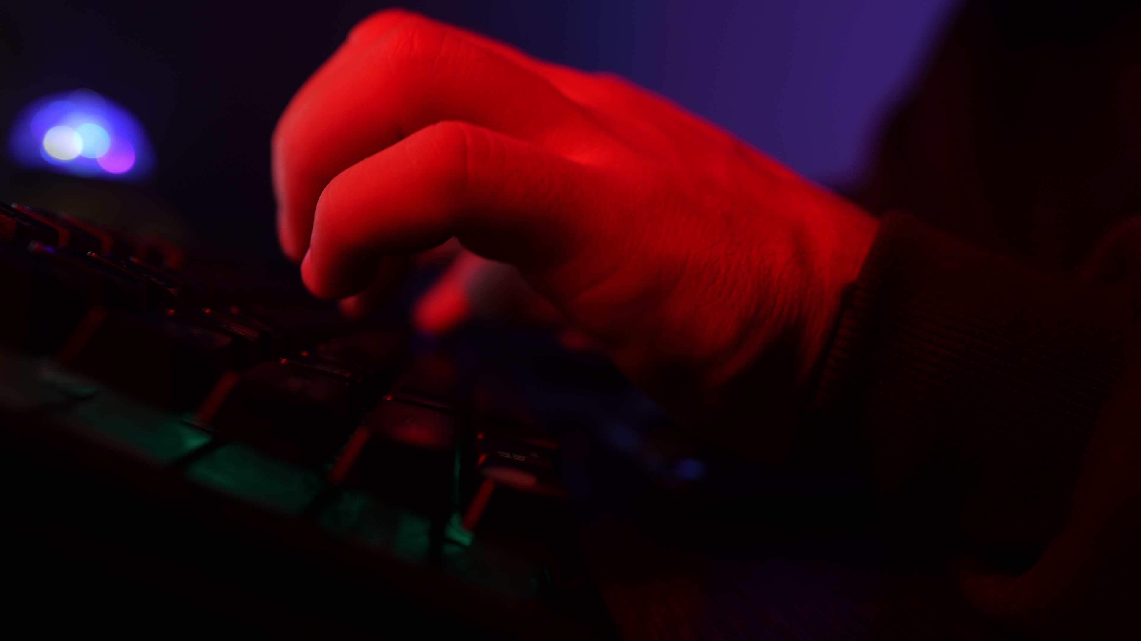 Close-up, Unrecognizable Man Using a Computer Keyboard to Code a Website in Neon Lighting ...