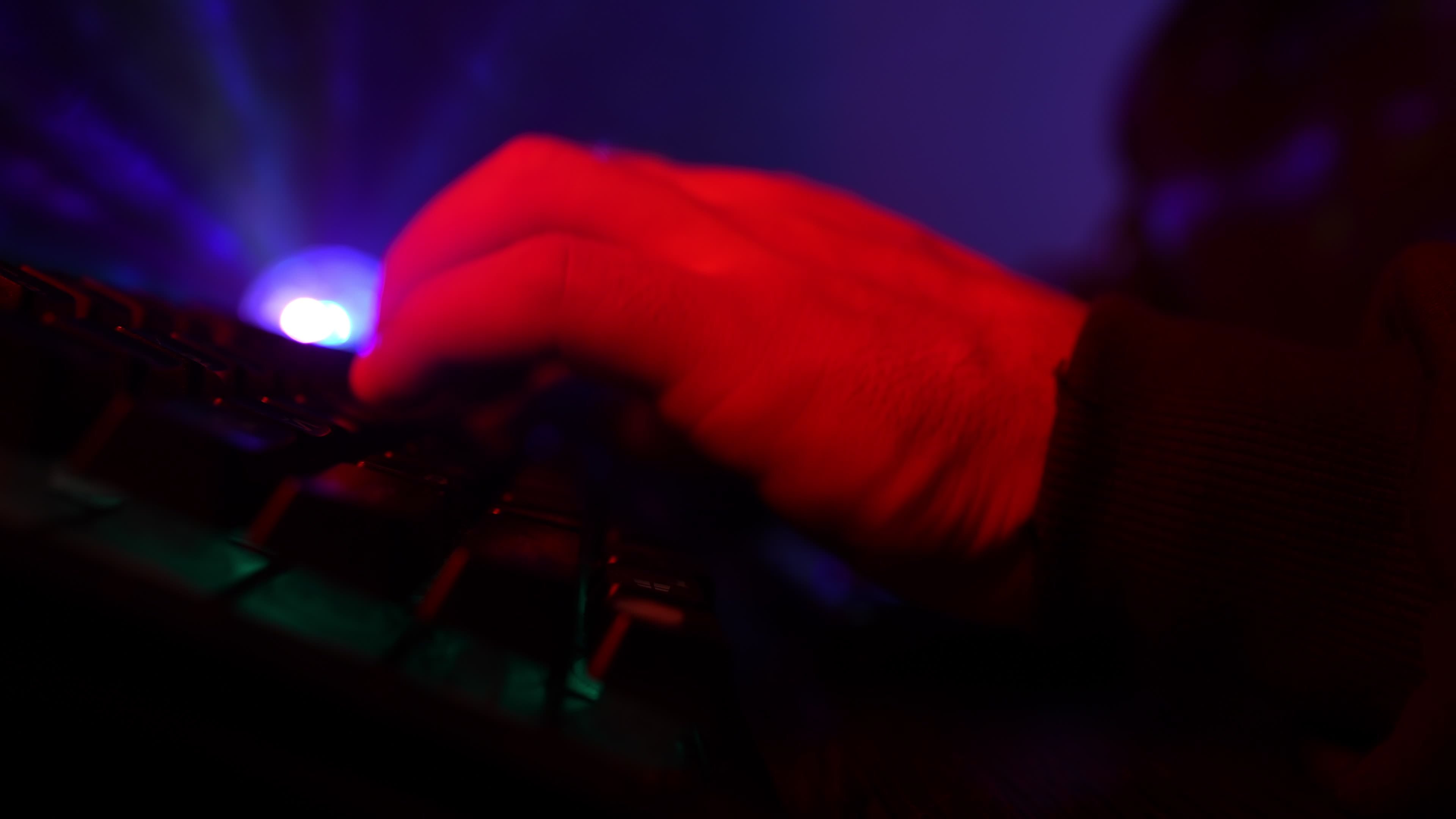 Close Up Unrecognizable Man Using A Computer Keyboard To Code A Website In Neon Lighting