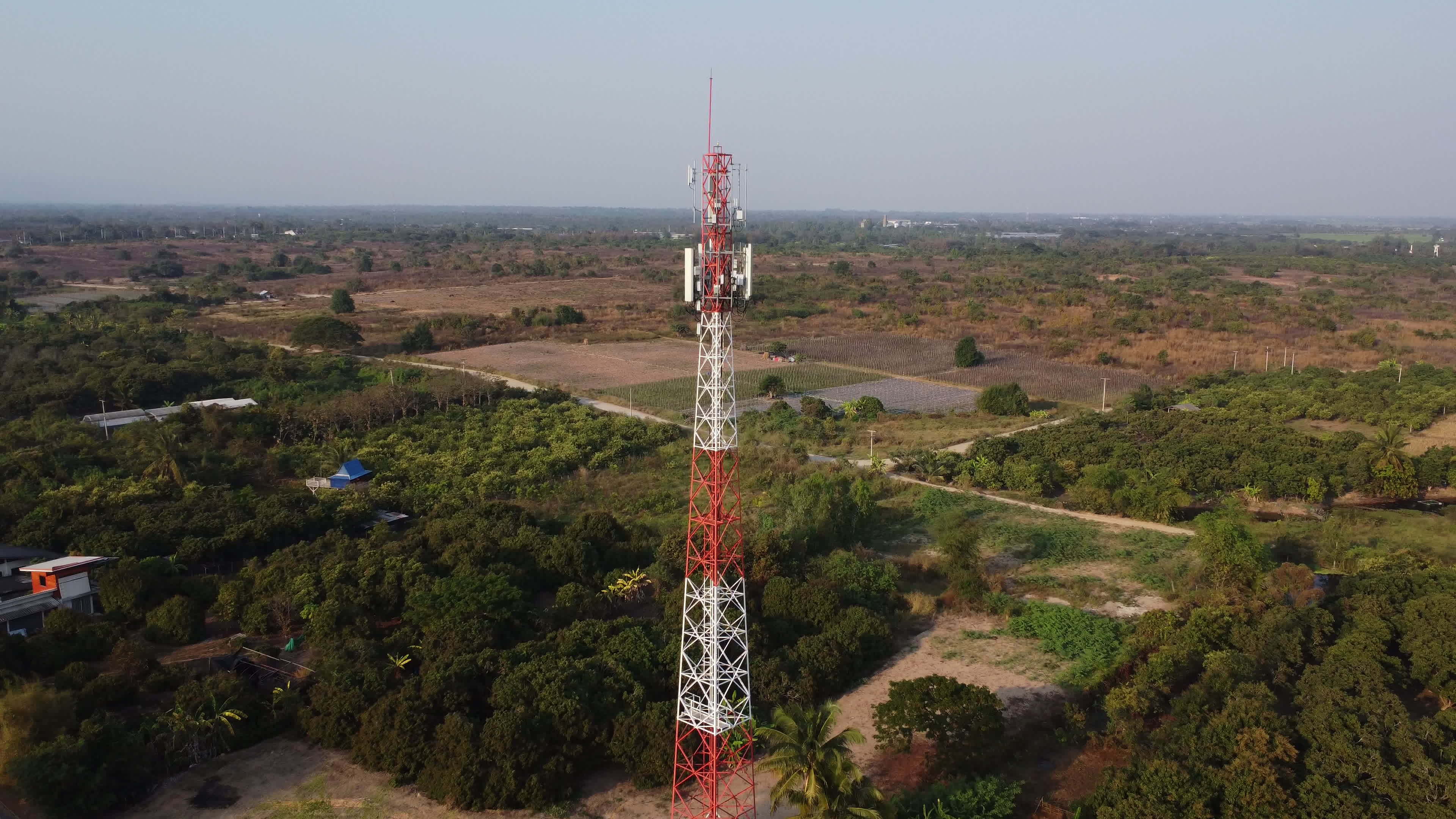 Transmission tower or pylon in aerial view. Telephone pole against rural landscape. Red and ...