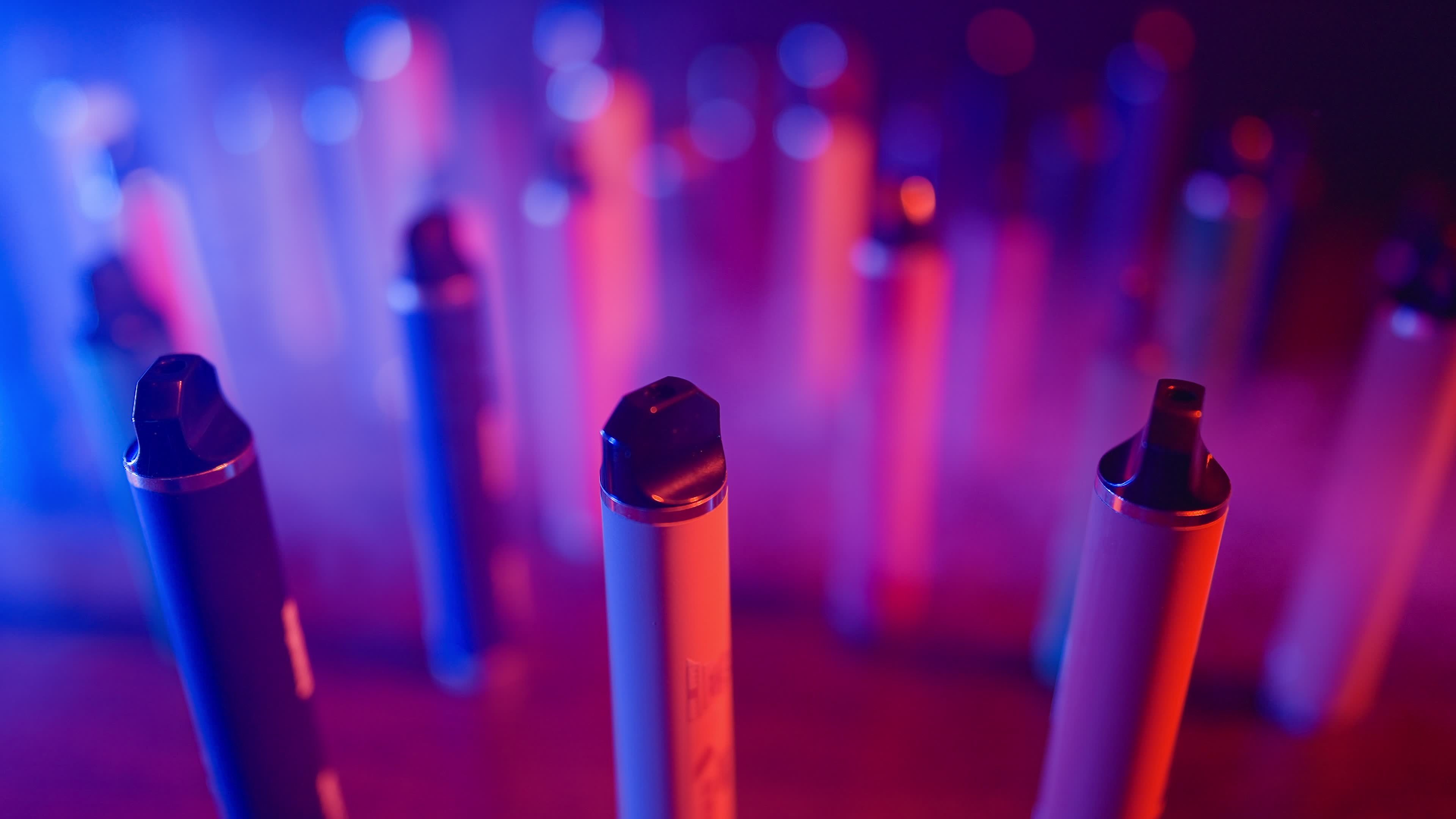 Lots Of E cigarettes And Vapes In Neon Lighting And Smoke Concept Of lots-of-e-cigarettes-and-vapes-in-neon-lighting-and-smoke-concept-of