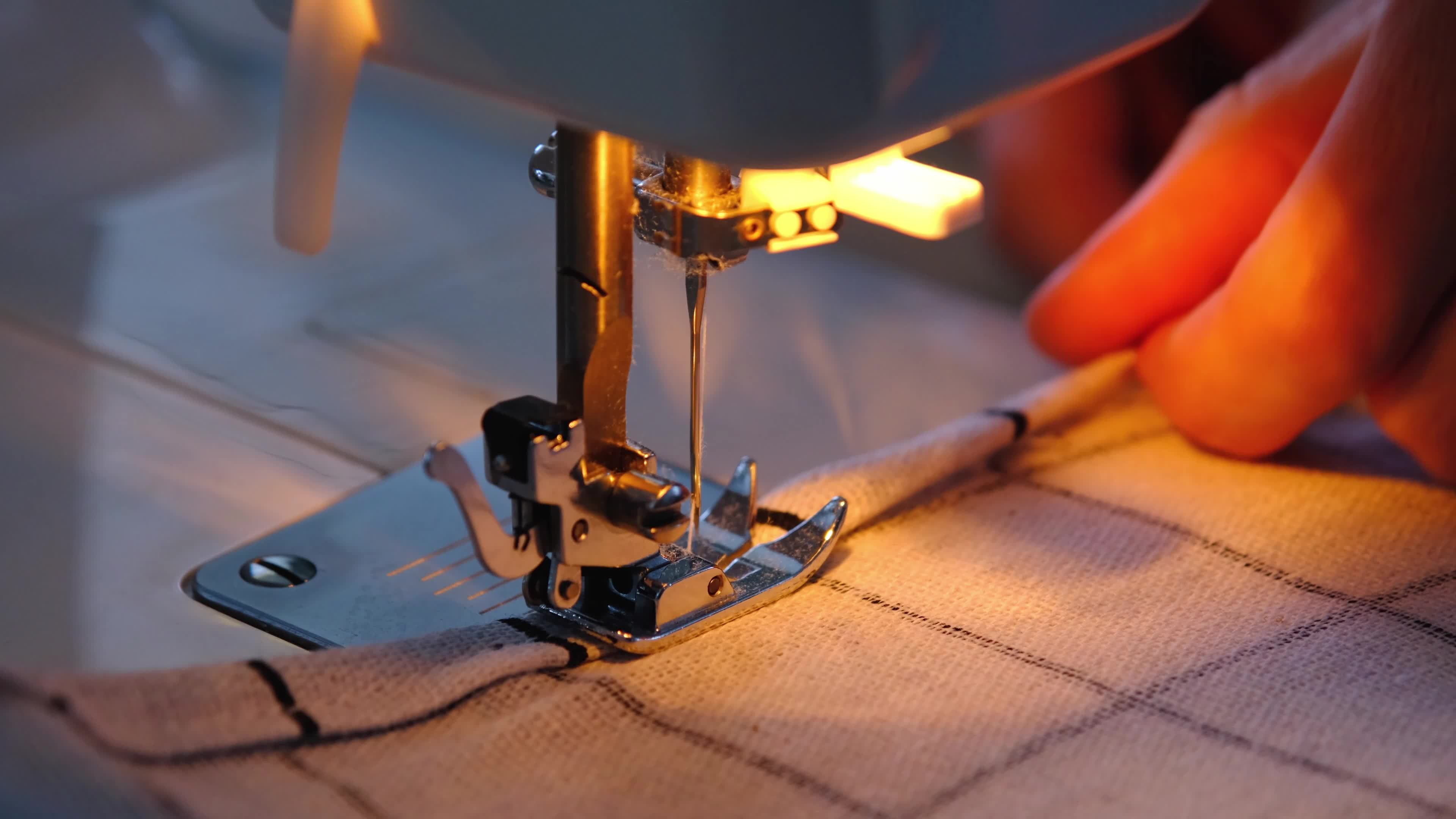 Sewing process on a sewing machine, a needle with a thread and a holder close-up stitch the ...