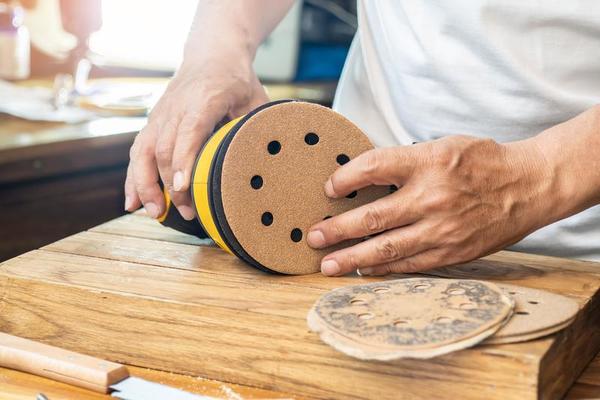 Carpenter attach sandpaper to an orbital sander or palm sander after remove the paper backing of the sandpaper.DIY maker and woodworking concept. selective focus 20410491 Stock Photo at Vecteezy
