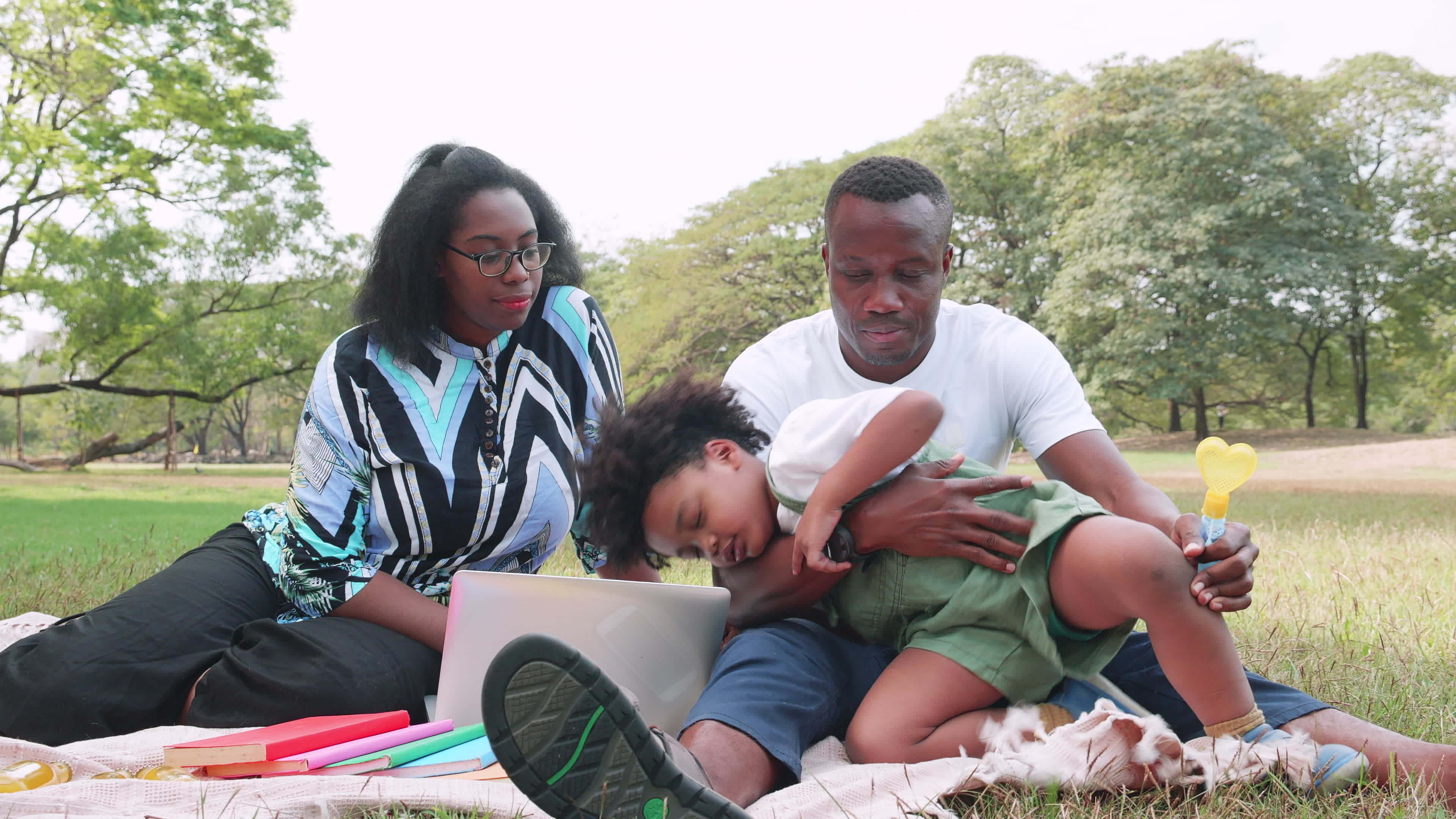 Happy African American family with son playful and funny in the park ...