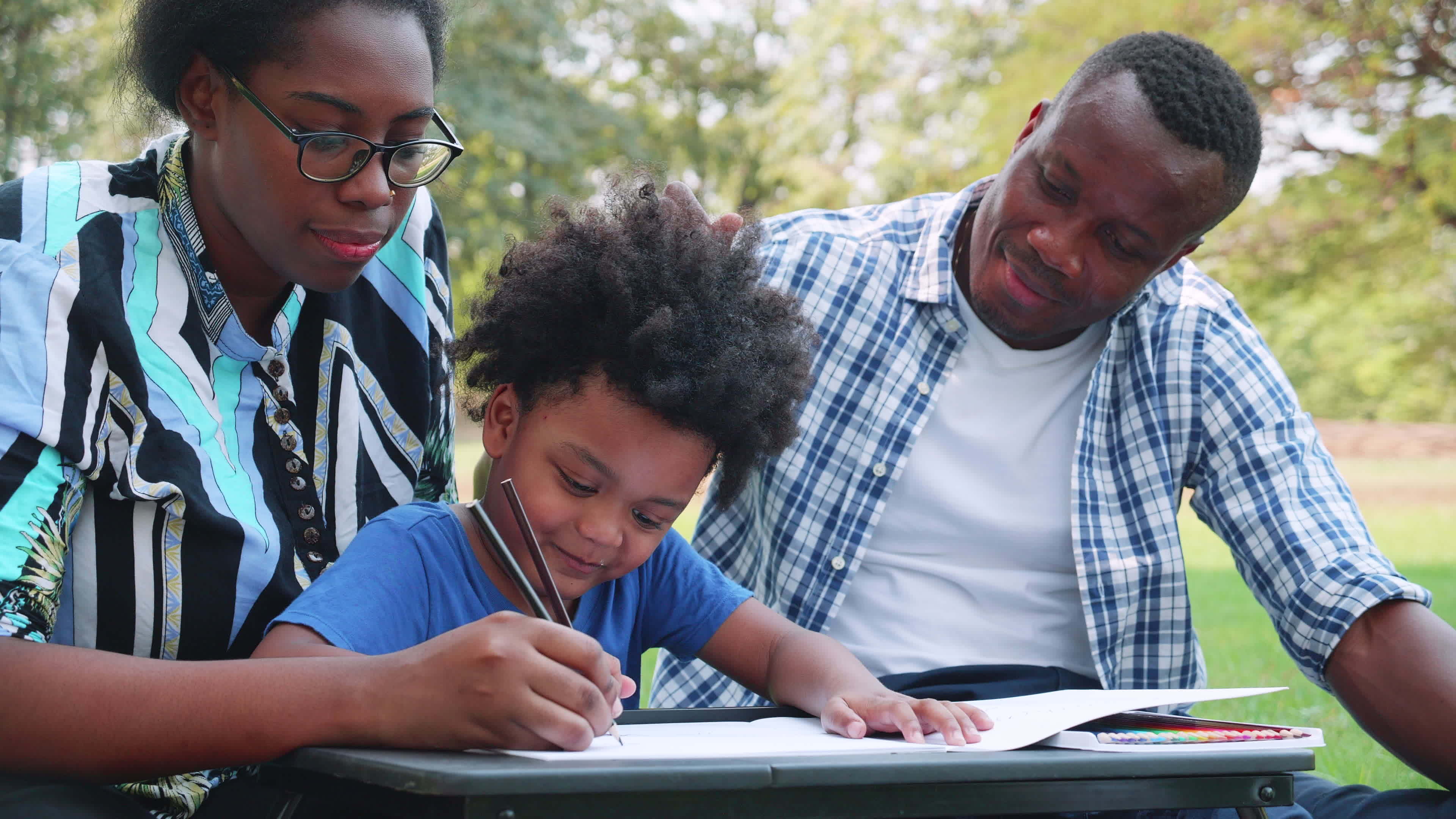 Happy African American family with son to sketching the tree in the ...