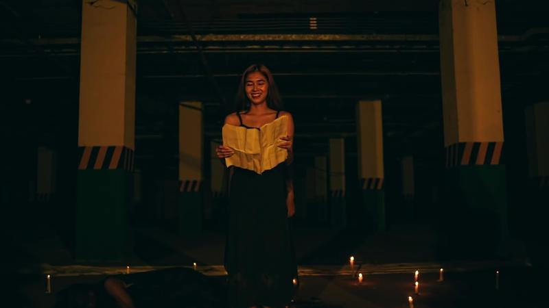 a woman with blonde hair and black clothes is reciting a ritual incantation surrounded by men ...