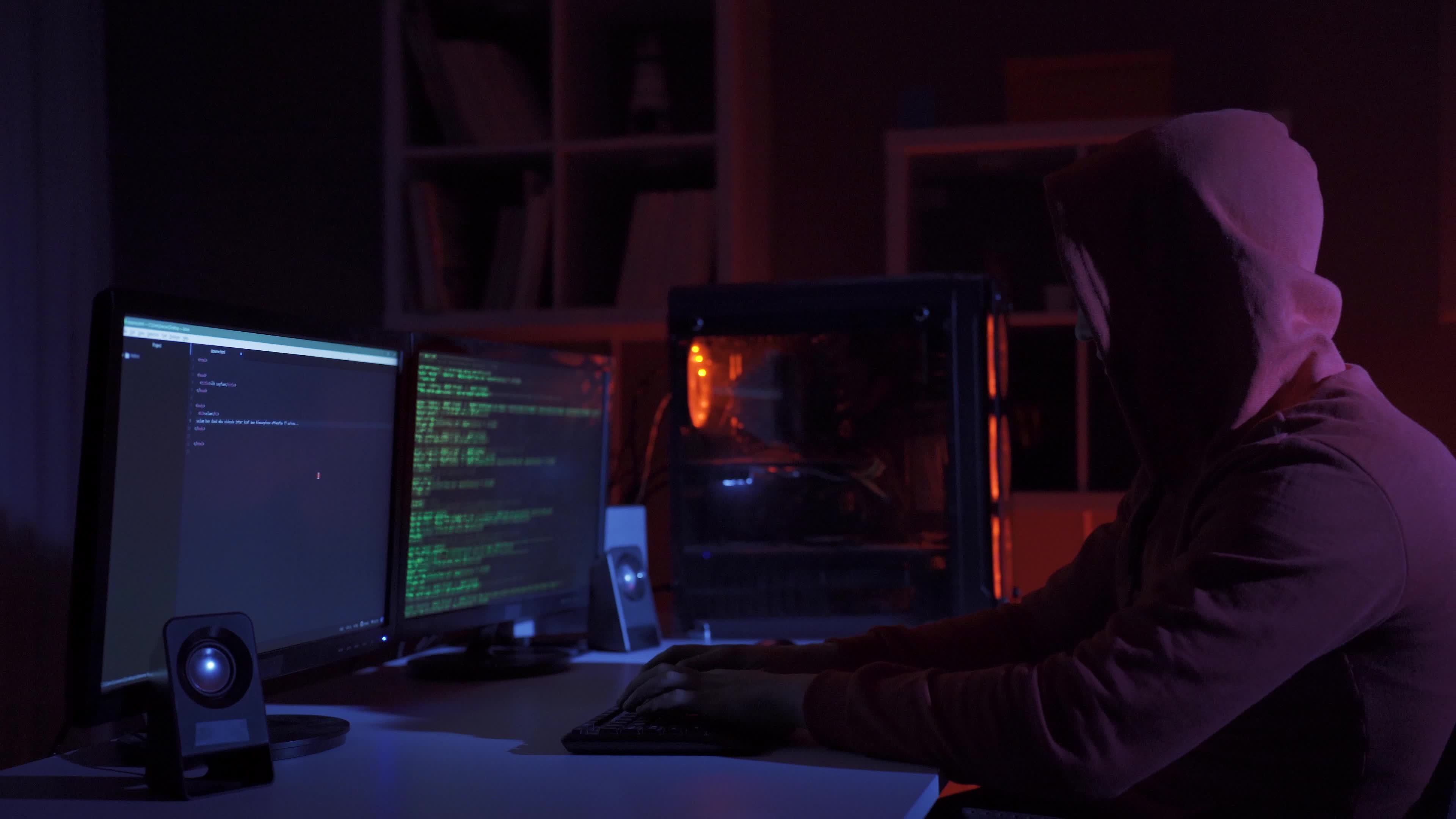 Side View Of Hacker Sitting Near Computer Monitors With Green Code