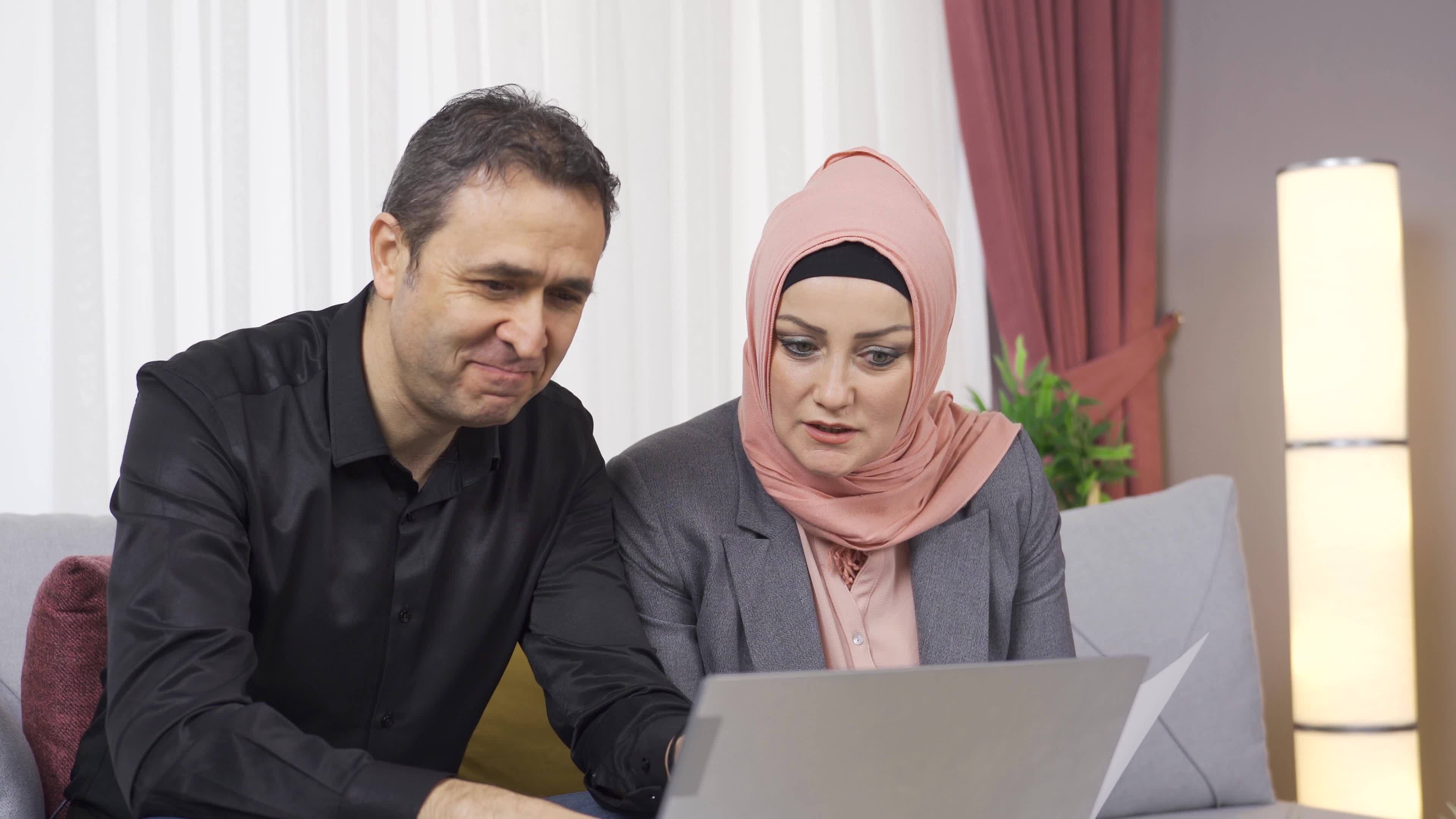 Muslim husband and wife work at home. Muslim couple working from home ...