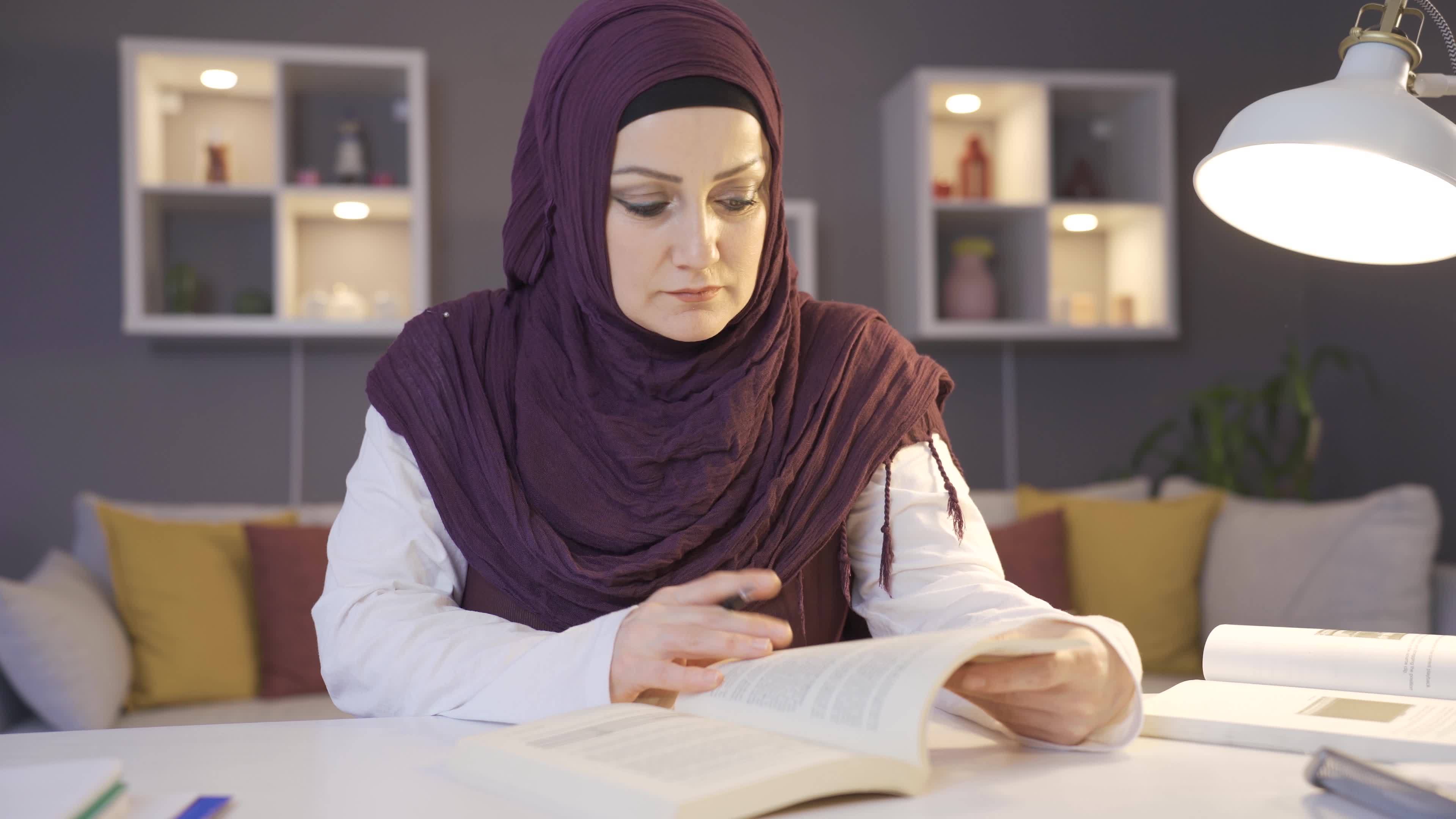 Muslim female student wearing hijab is studying for her lessons. A Muslim female university ...