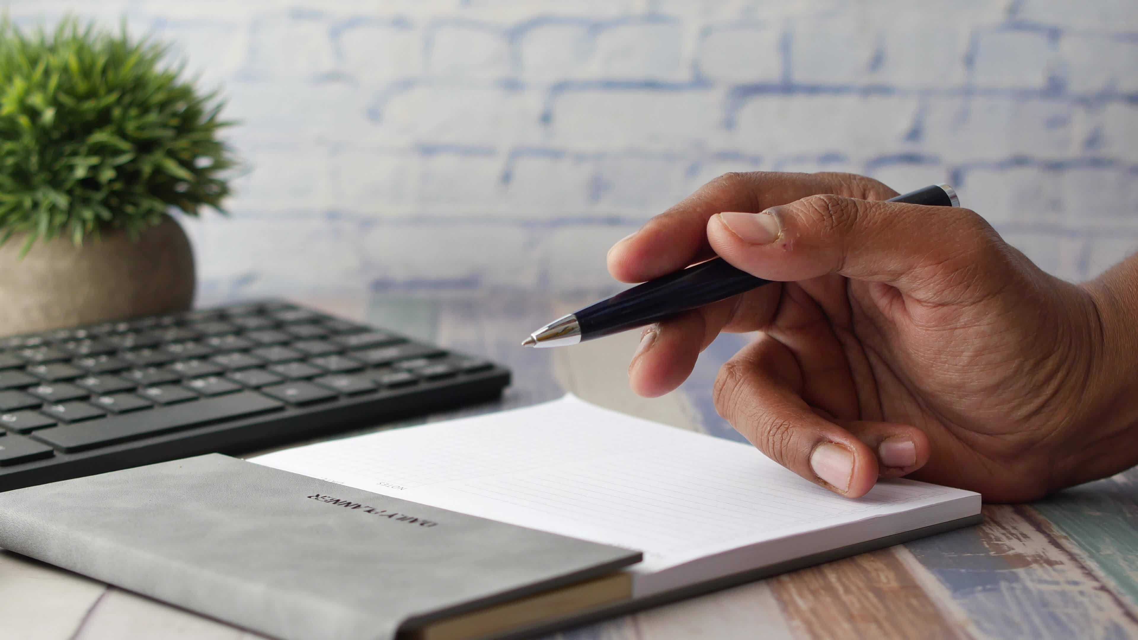 man hand writing on notepad while sited 21547853 Stock Video at Vecteezy