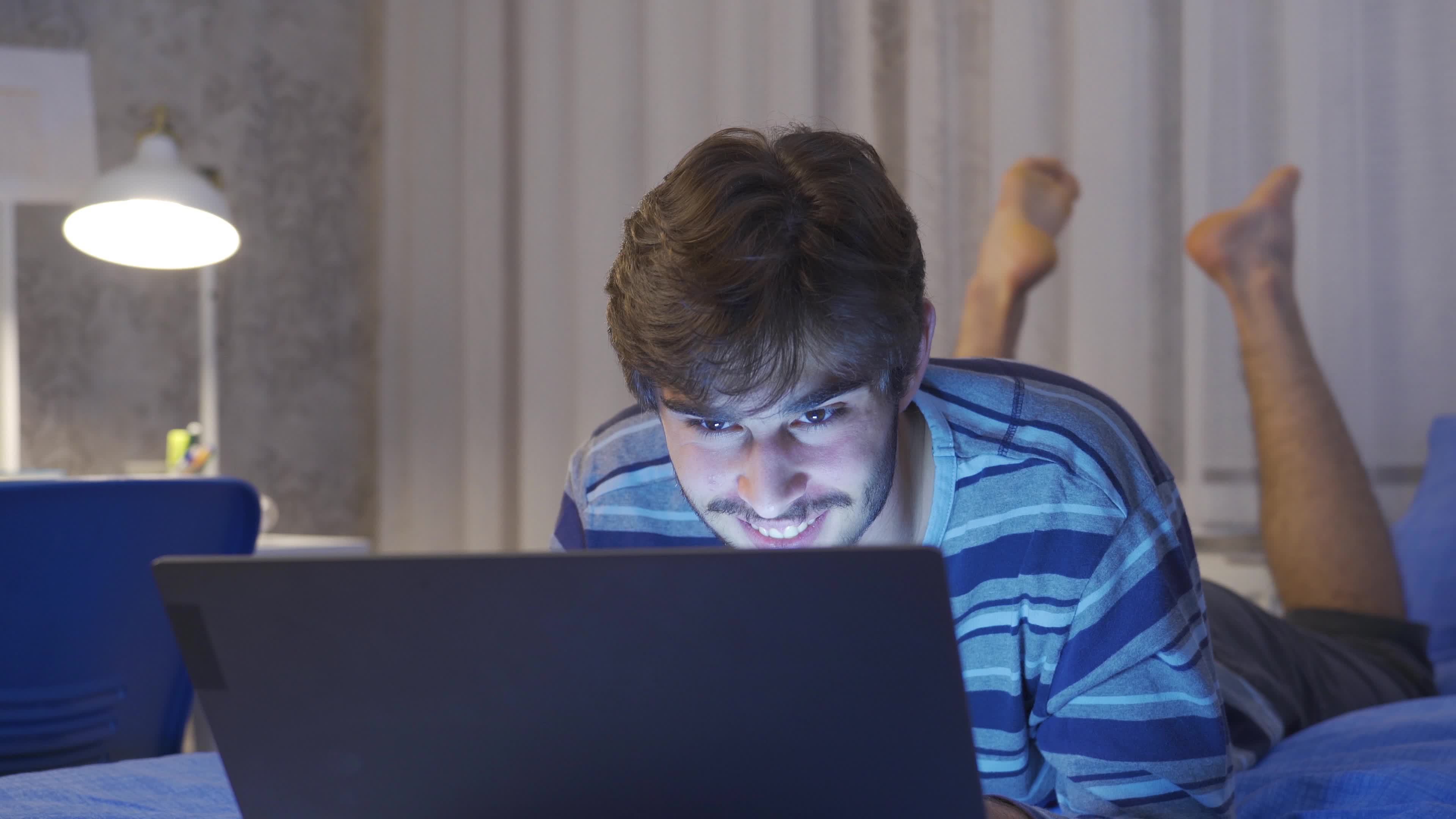 Young man chatting on laptop in bed. Happy. Young man chatting on ... Young man chatting on laptop in bed. Happy. Young man chatting on ...