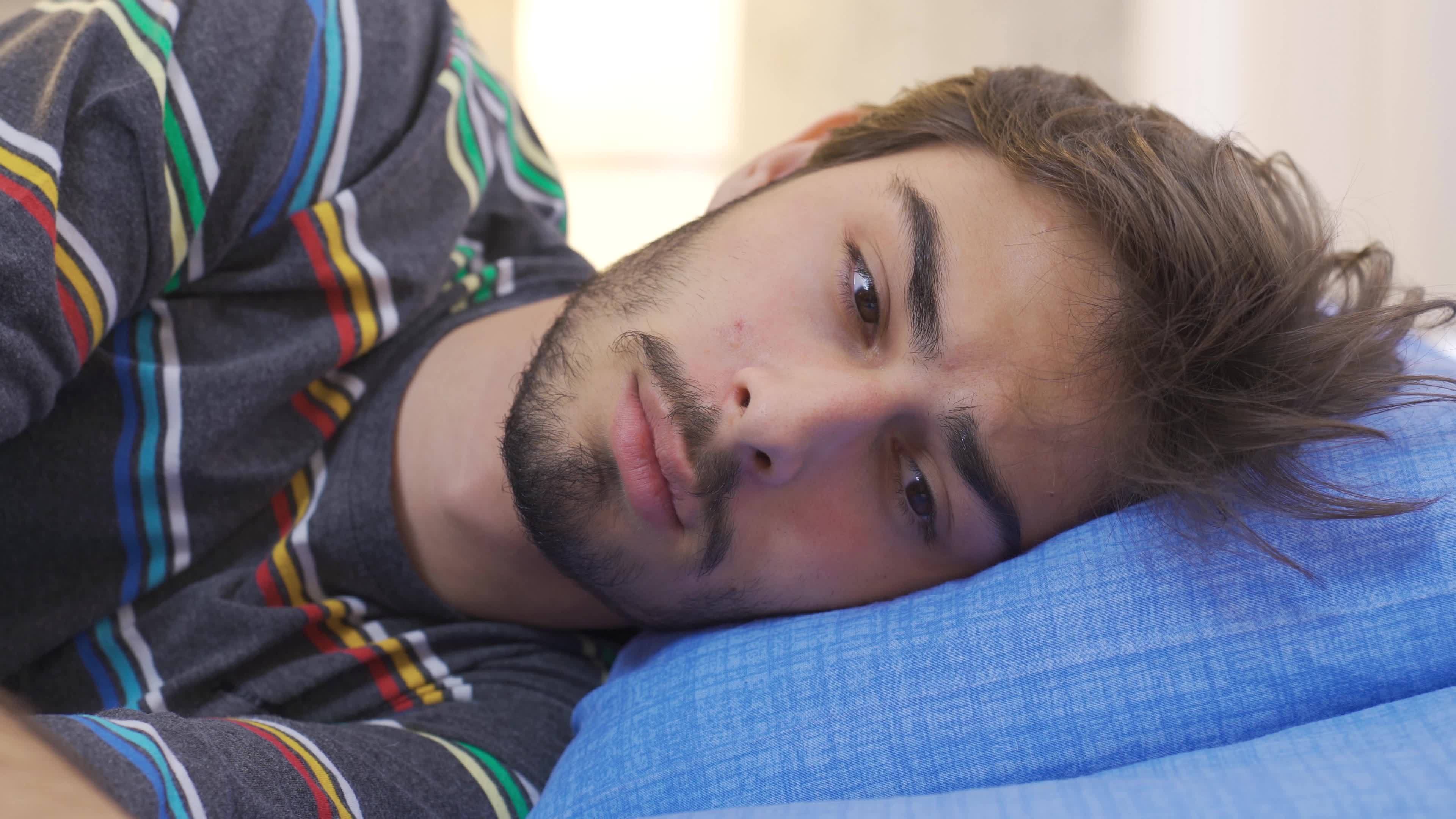 Thoughtful young man feeling unhappy in his room. Unhappy young man ...