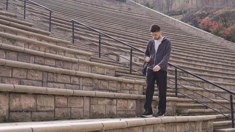 Unhappy male student sad and depressed. Lonely young man walking alone ...