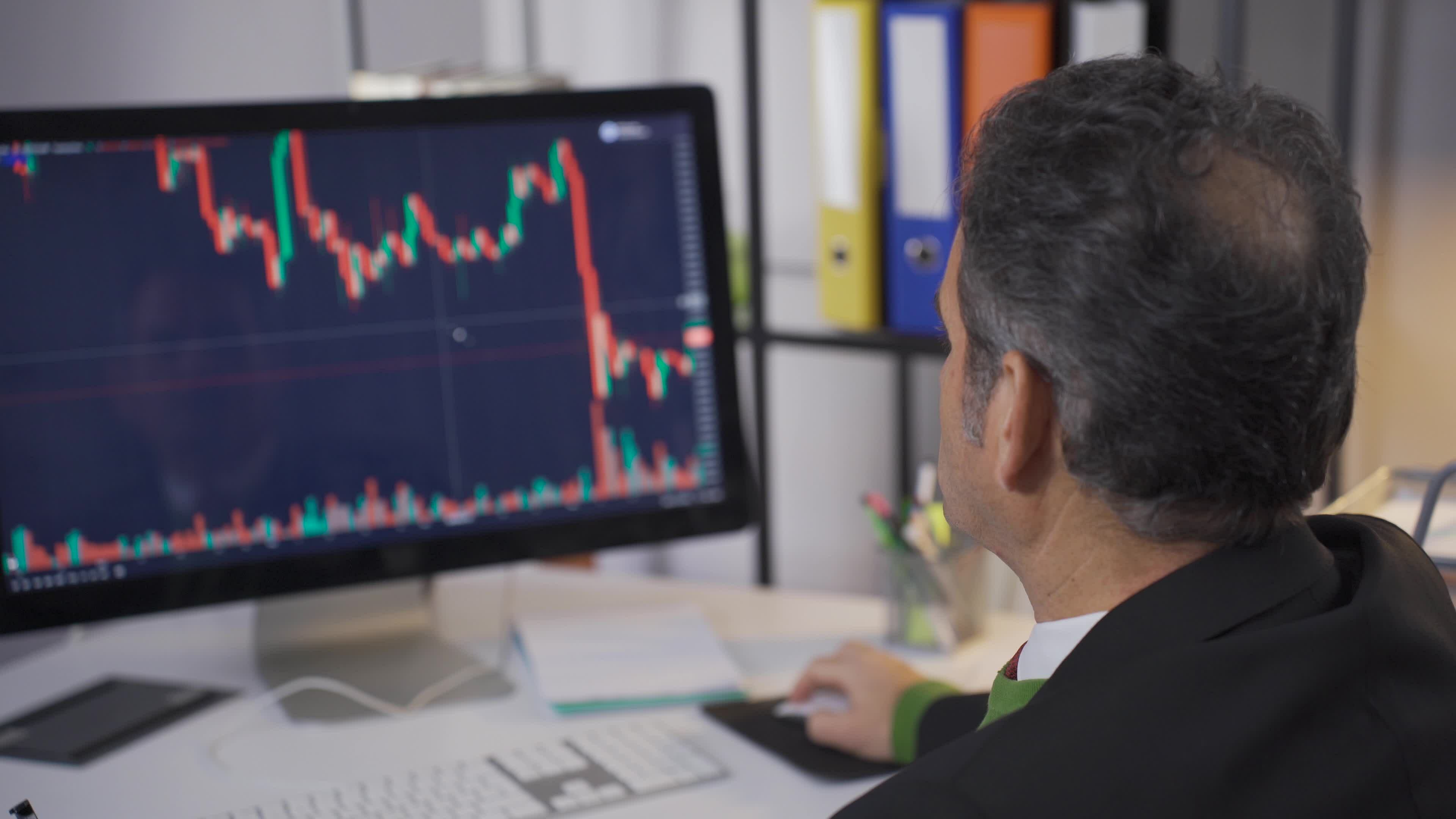 Thoughtful Man Researching And Analyzing Stock Market Data The Trader
