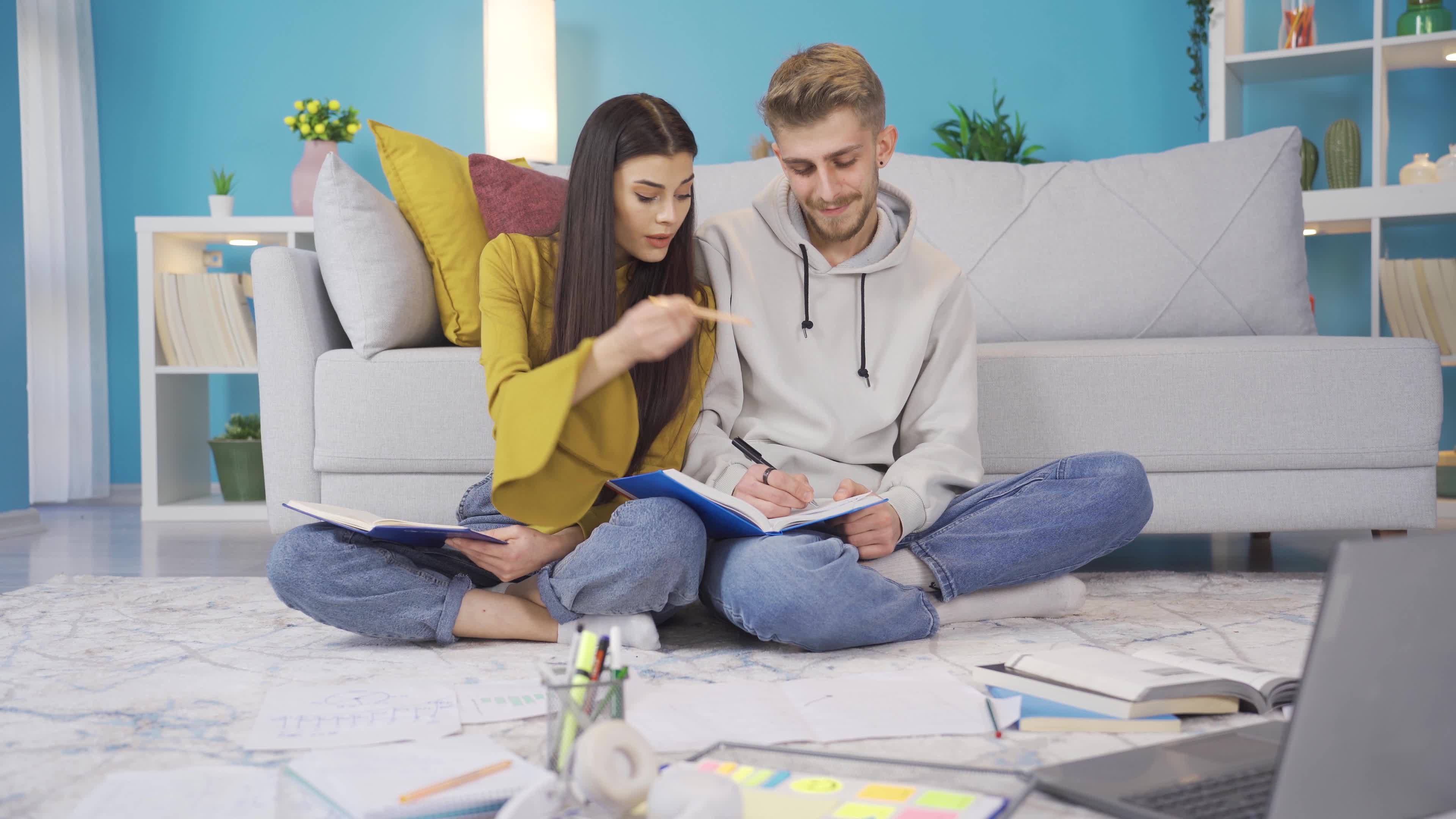 Happy young student couple studying at home. Young couple studying at university study together ...