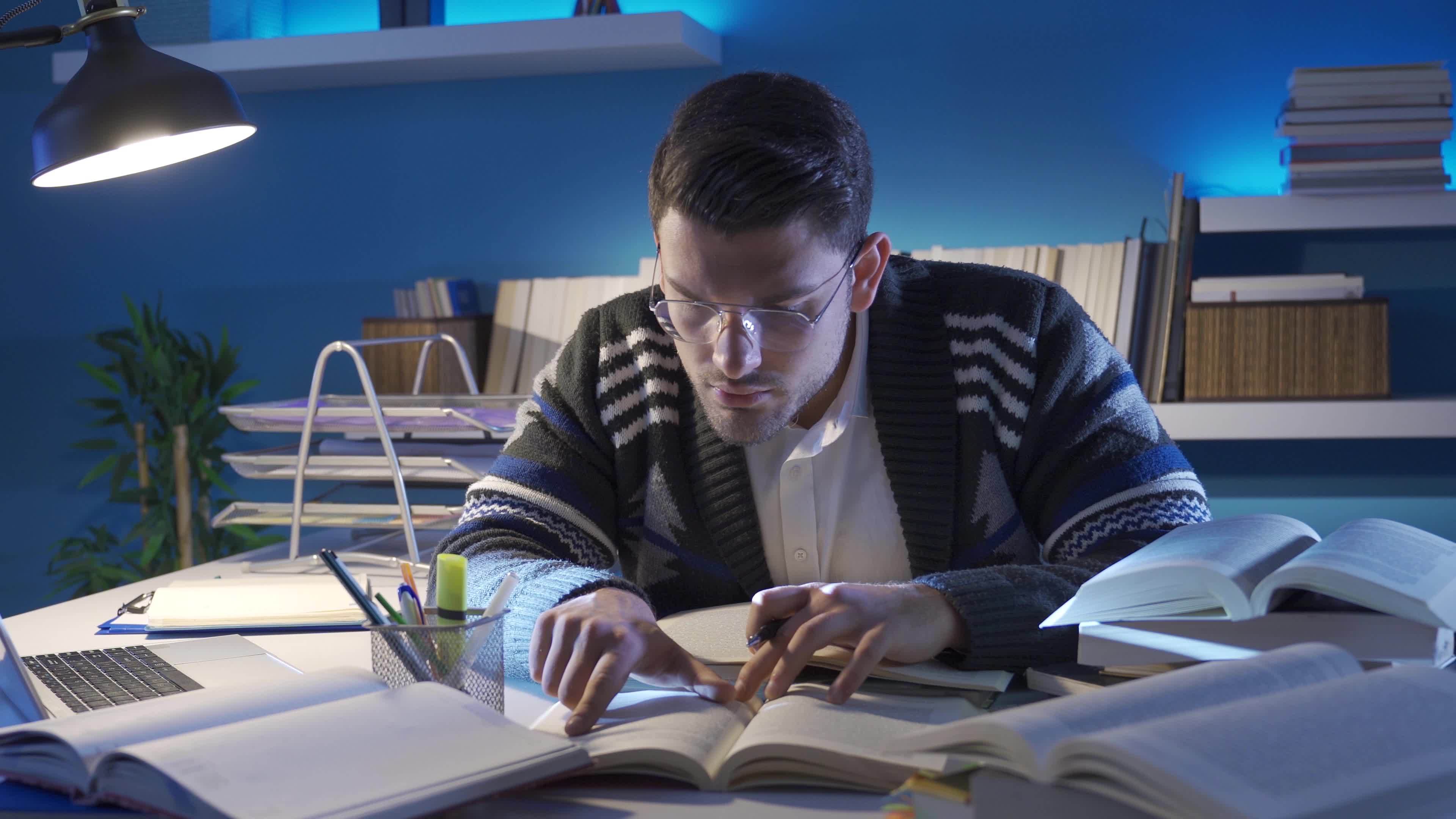 Historian young man examine books and documents in his research. Thoughtful researcher man ...