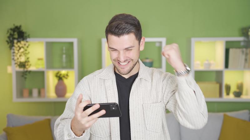 Phone addicted young man is happy when he wins the game. Phone ... Phone addicted young man is happy when he wins the game. Phone ...