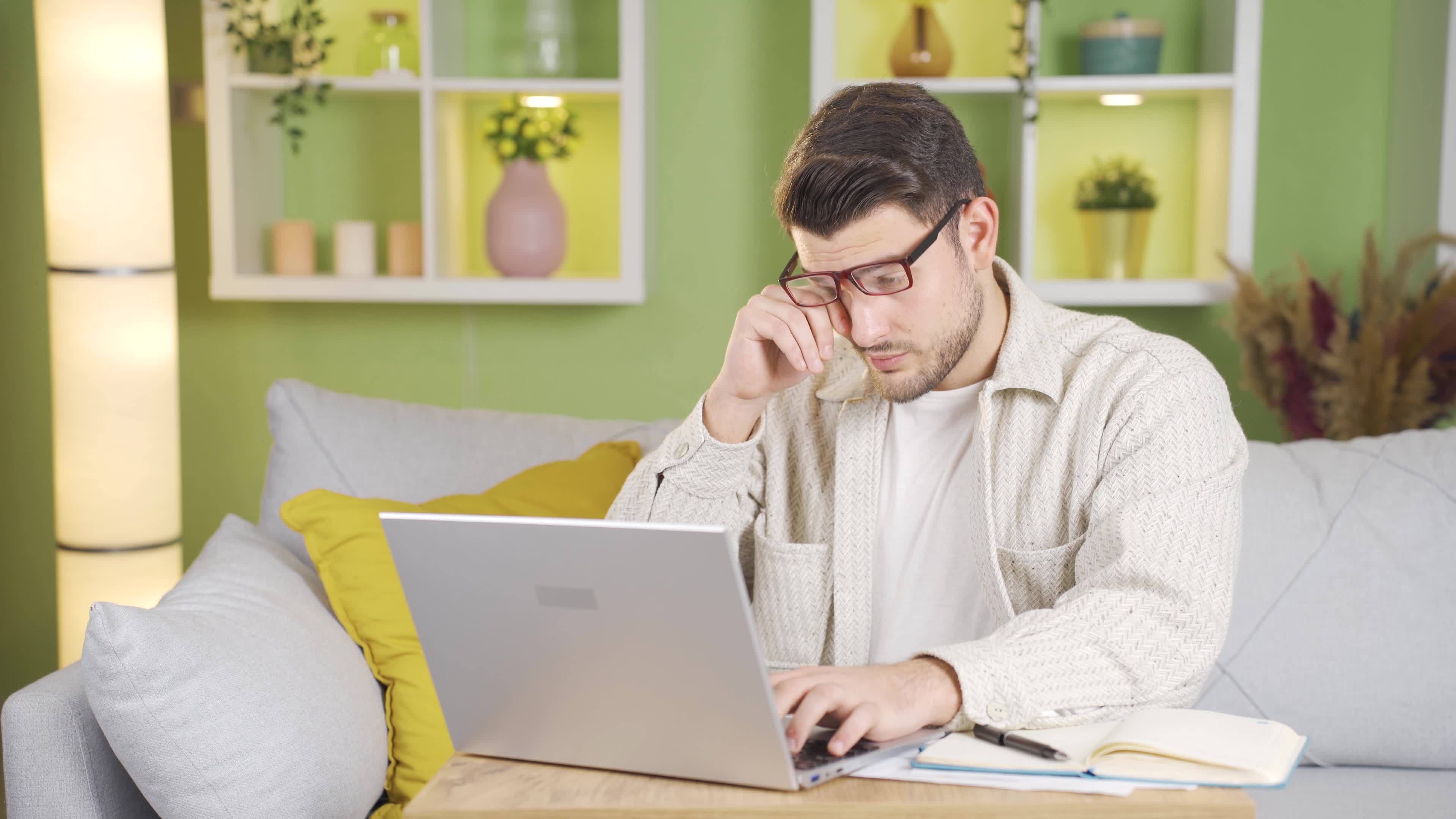 Man doing his work using laptop has sore eyes from looking at the ...