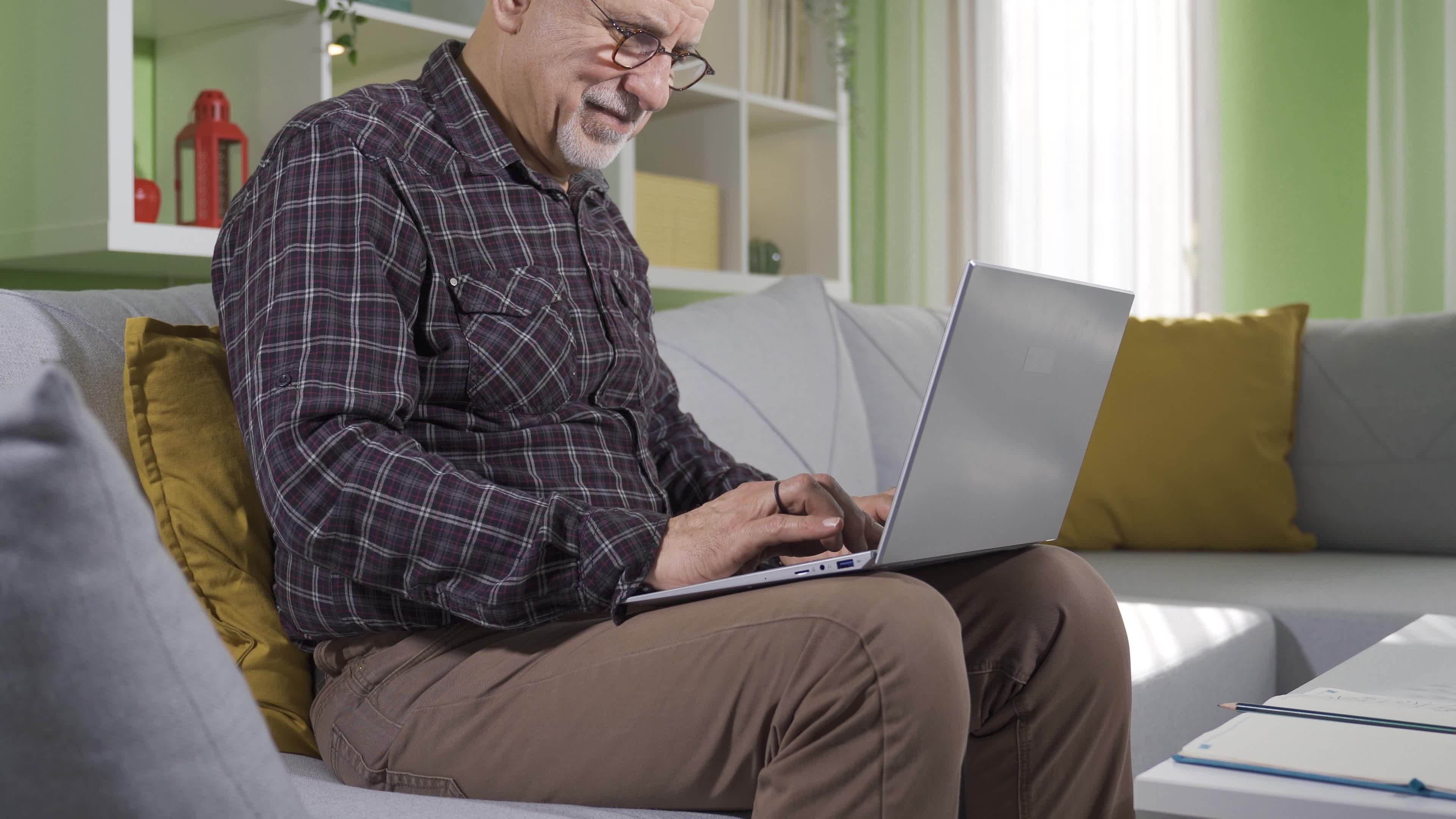 Old man at home using laptop and smiling, having fun and cheerful. Old ...