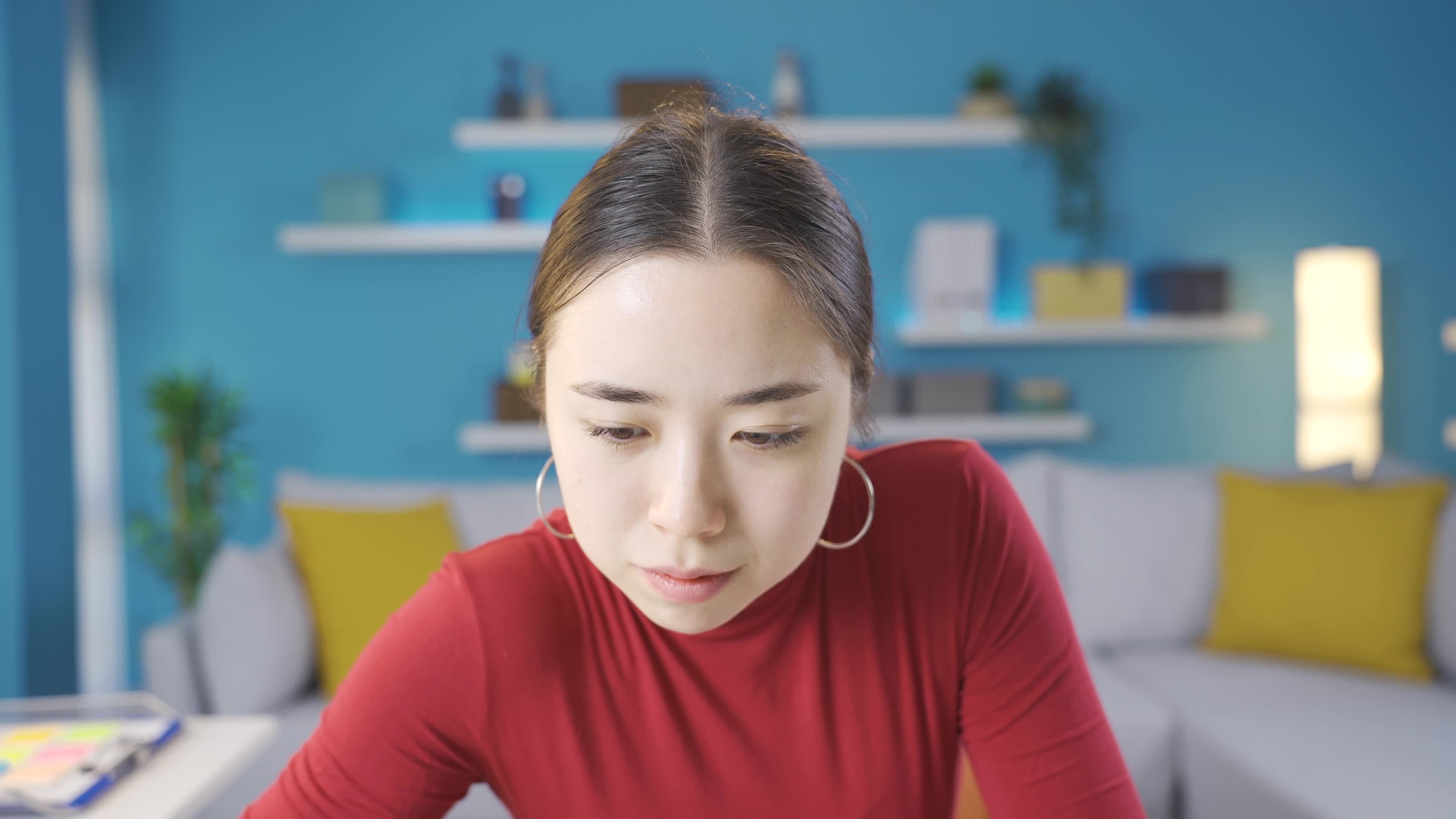Asian Woman Working In Home Office Working From Laptop In A Stressed
