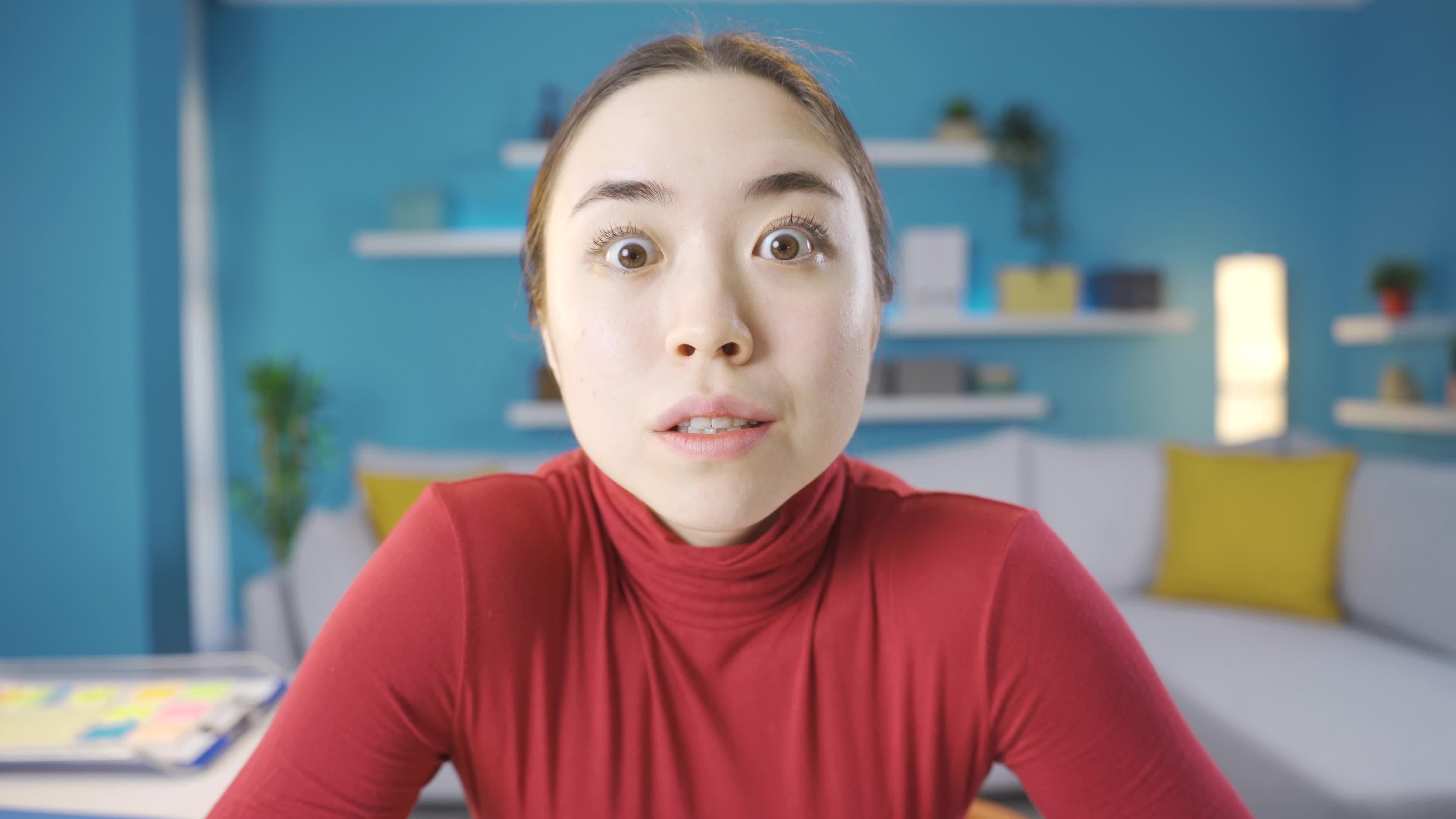 Young Asian woman makes a confused facial expression towards the camera ...