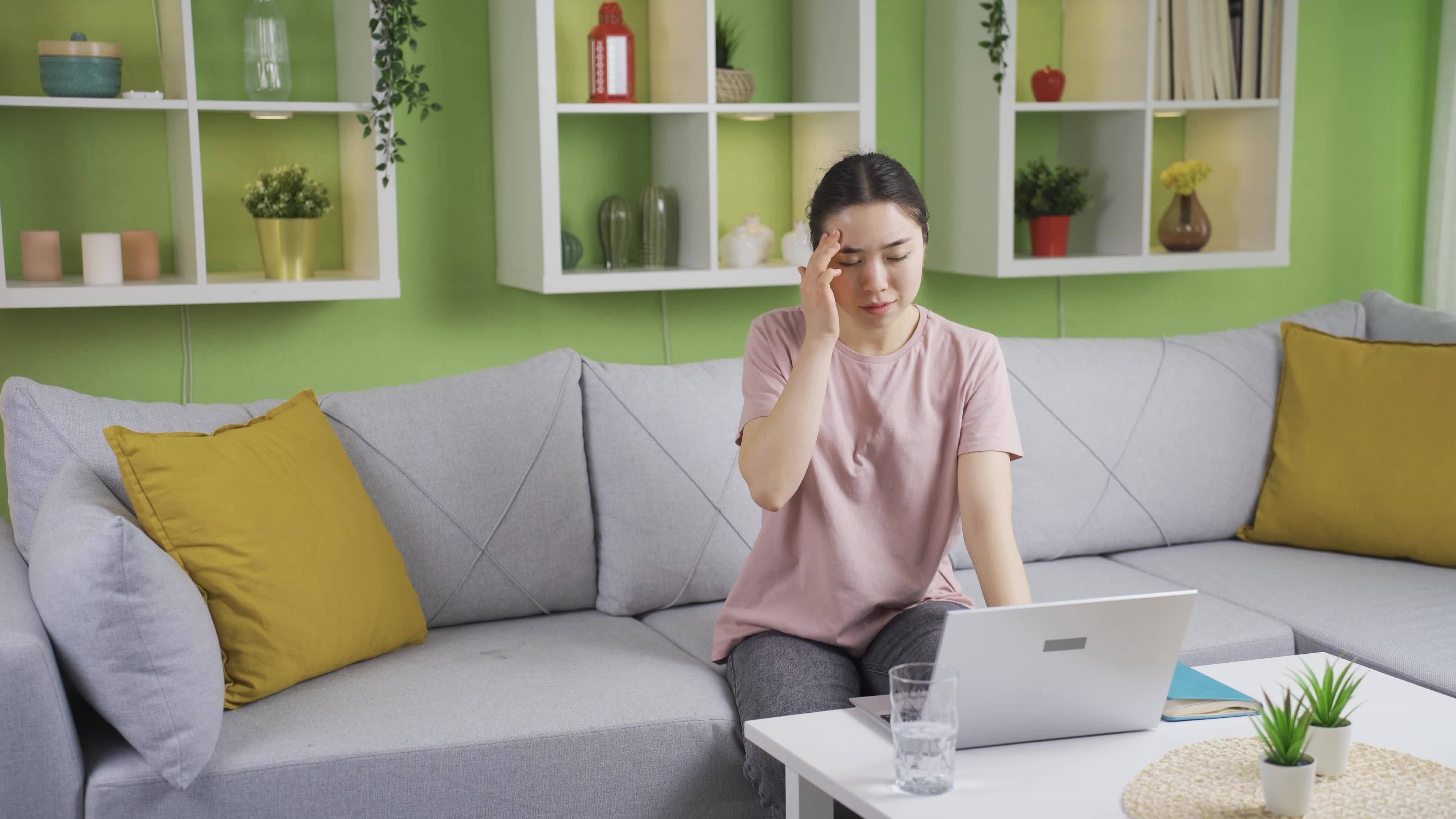 Asian young woman suffering from vertigo is fainting. Young asian woman dizzy at home is ...