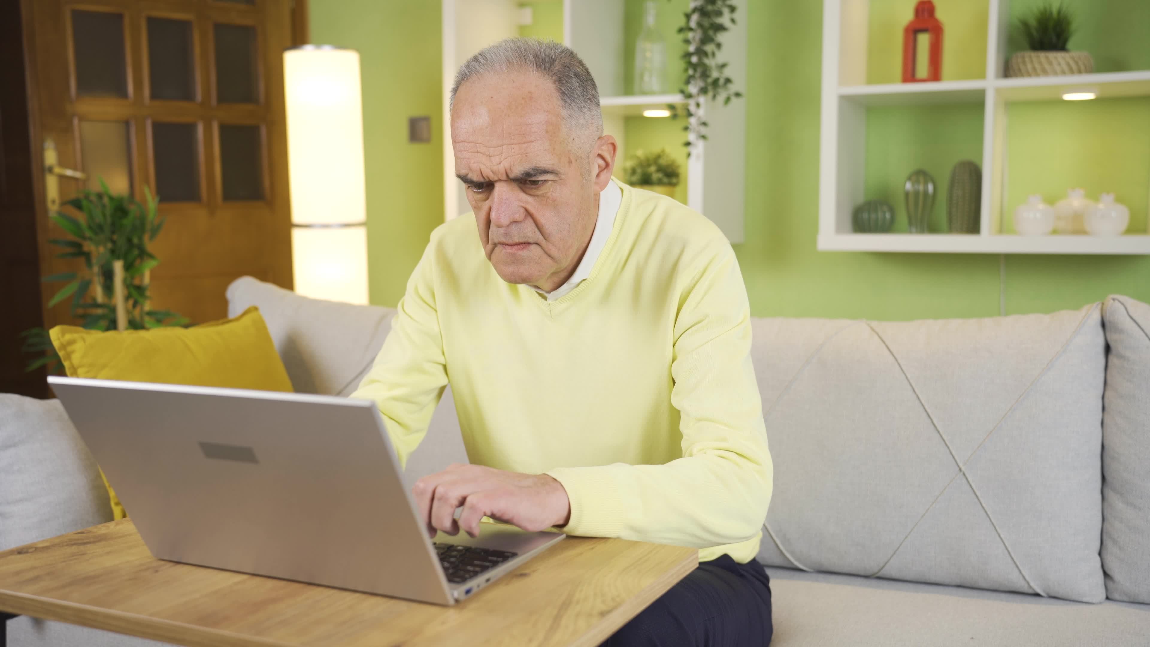 velho homem usando computador portátil às casa e lutando. tecnologia ...