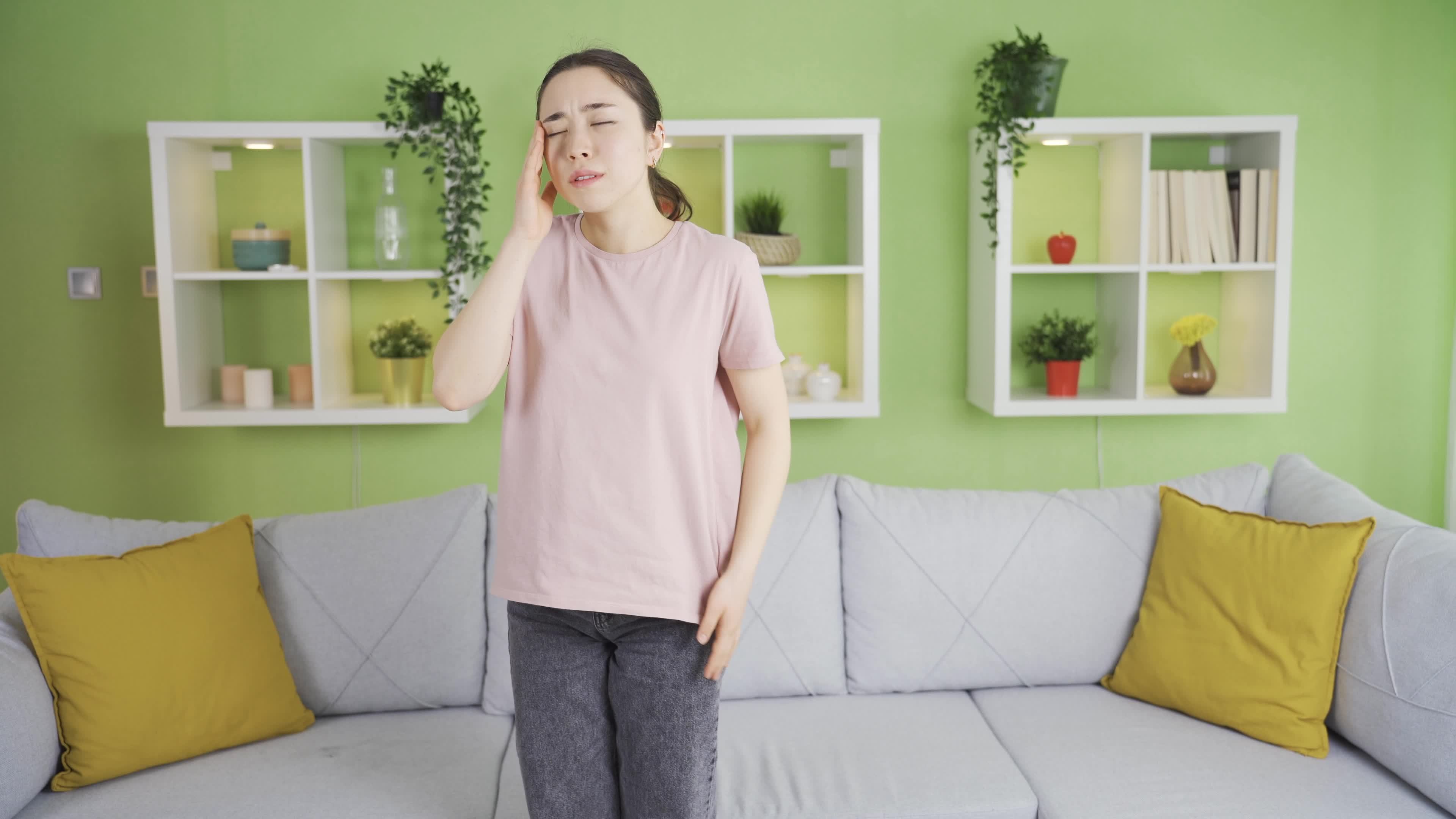 Young asian woman fainting at home. The young woman in the house faints. Loss of balance ...