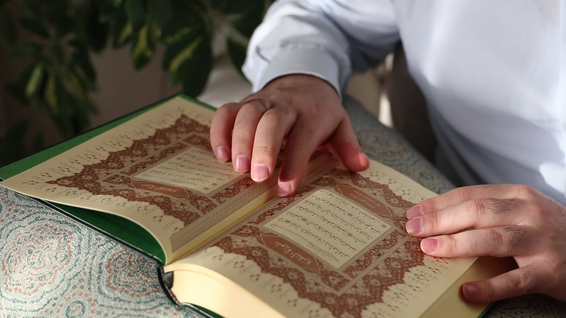 Hand-changing pages of the Quran standing on the table, a Muslim young ... Hand-changing pages of the Quran standing on the table, a Muslim young ...