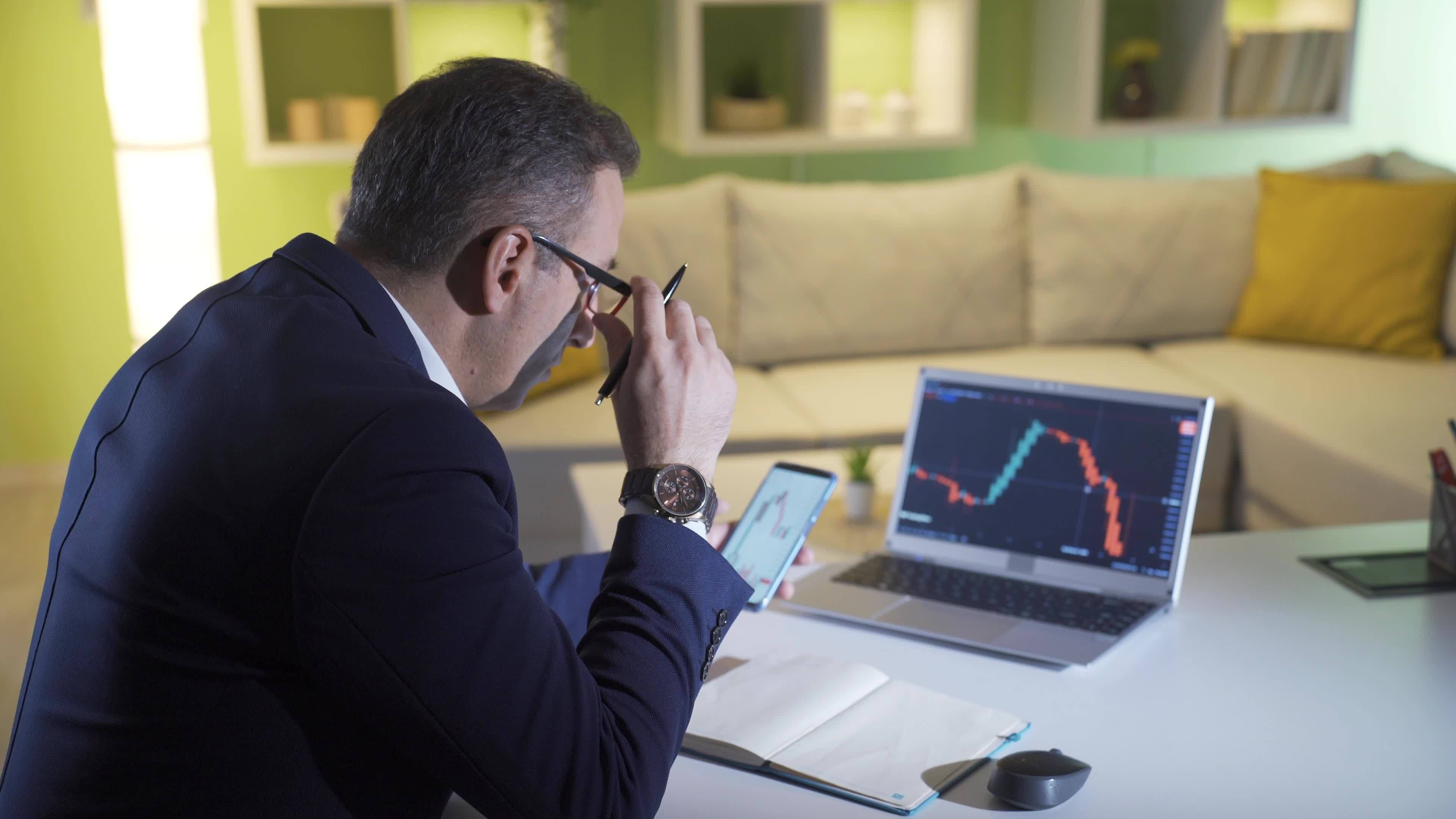 Man Using Computer Viewing Real Time Stocks And Currency Market Charts