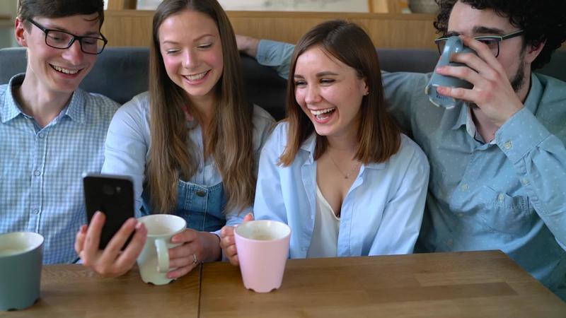 Young Friends Sit In A Cafe Drink Coffee And Have Fun Communicating Slow Motion 22749626 Stock
