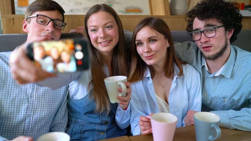 Young Friends Sit In A Cafe Drink Coffee And Have Fun Communicating Slow Motion 22749939 Stock