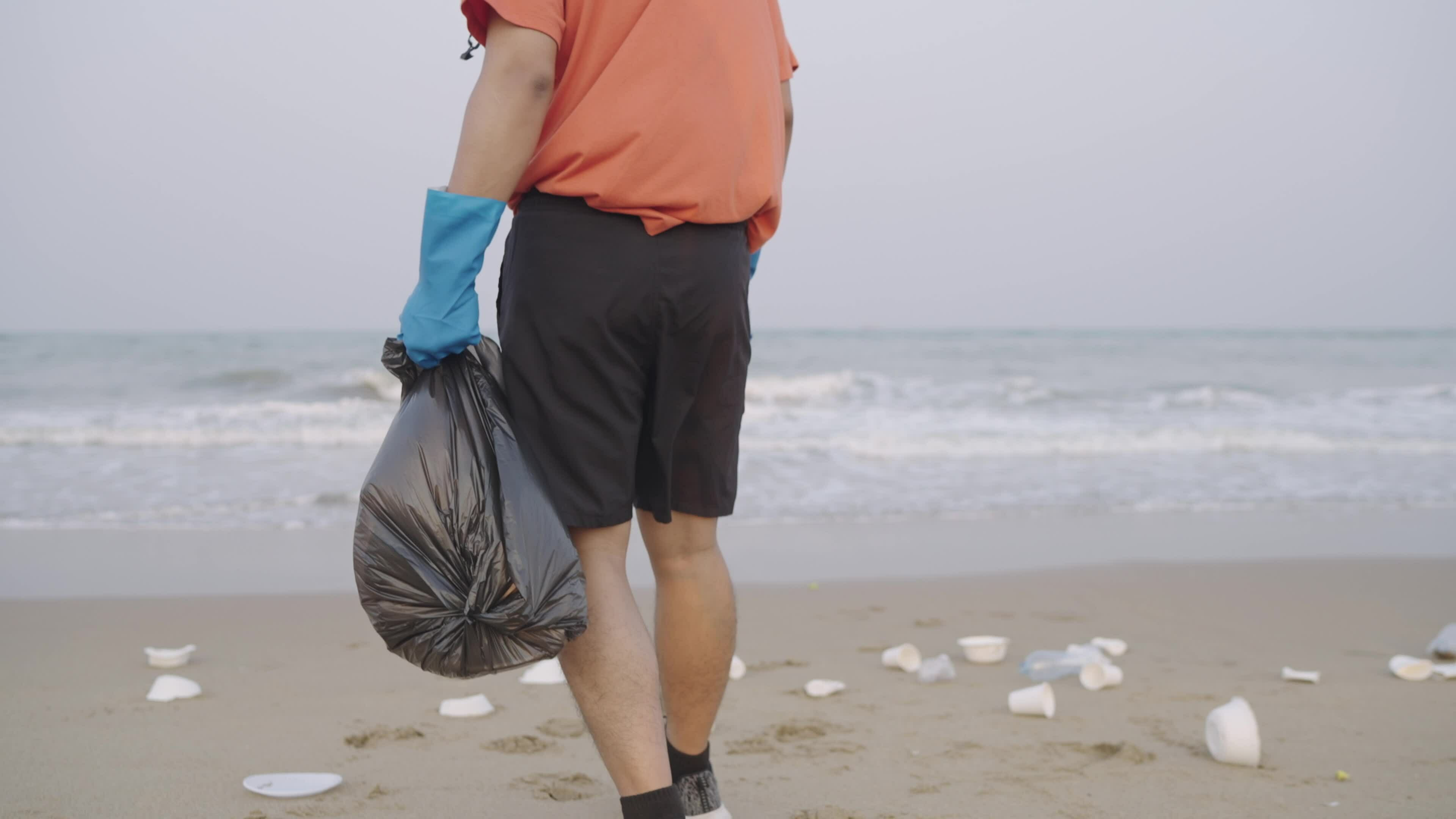 Volunteers walk and pick up garbage on the beach. Cleaner collecting ... Volunteers walk and pick up garbage on the beach. Cleaner collecting ...