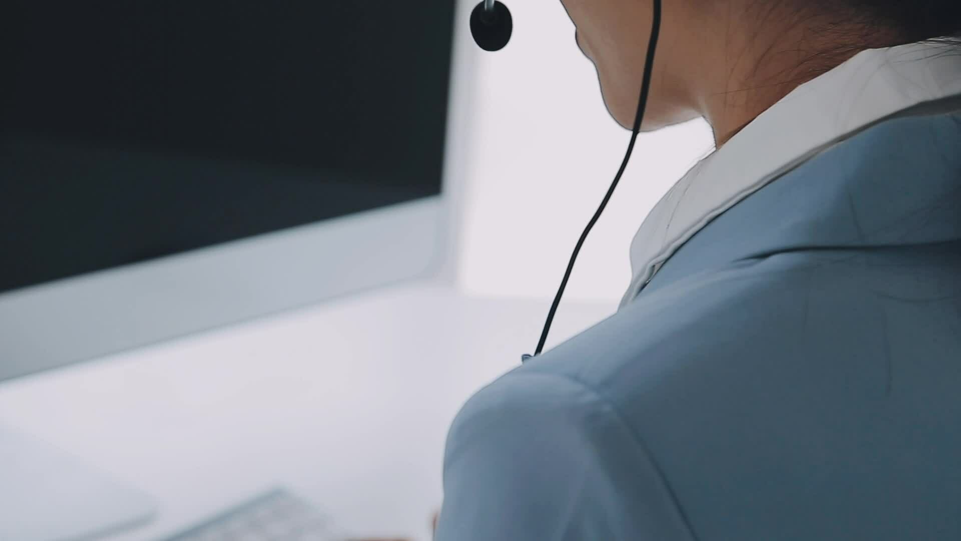 Call center agent with headset working on support hotline in modern office with copy space ...