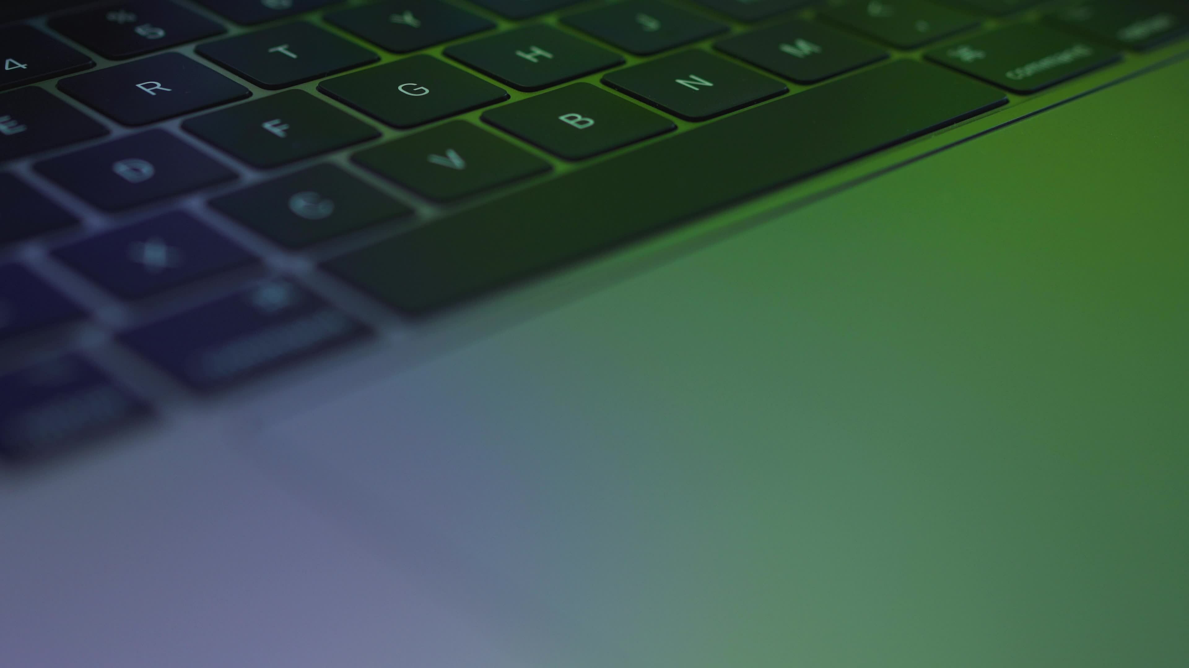 Close up laptop keyboard with multi-colored highlights on it. Very ...