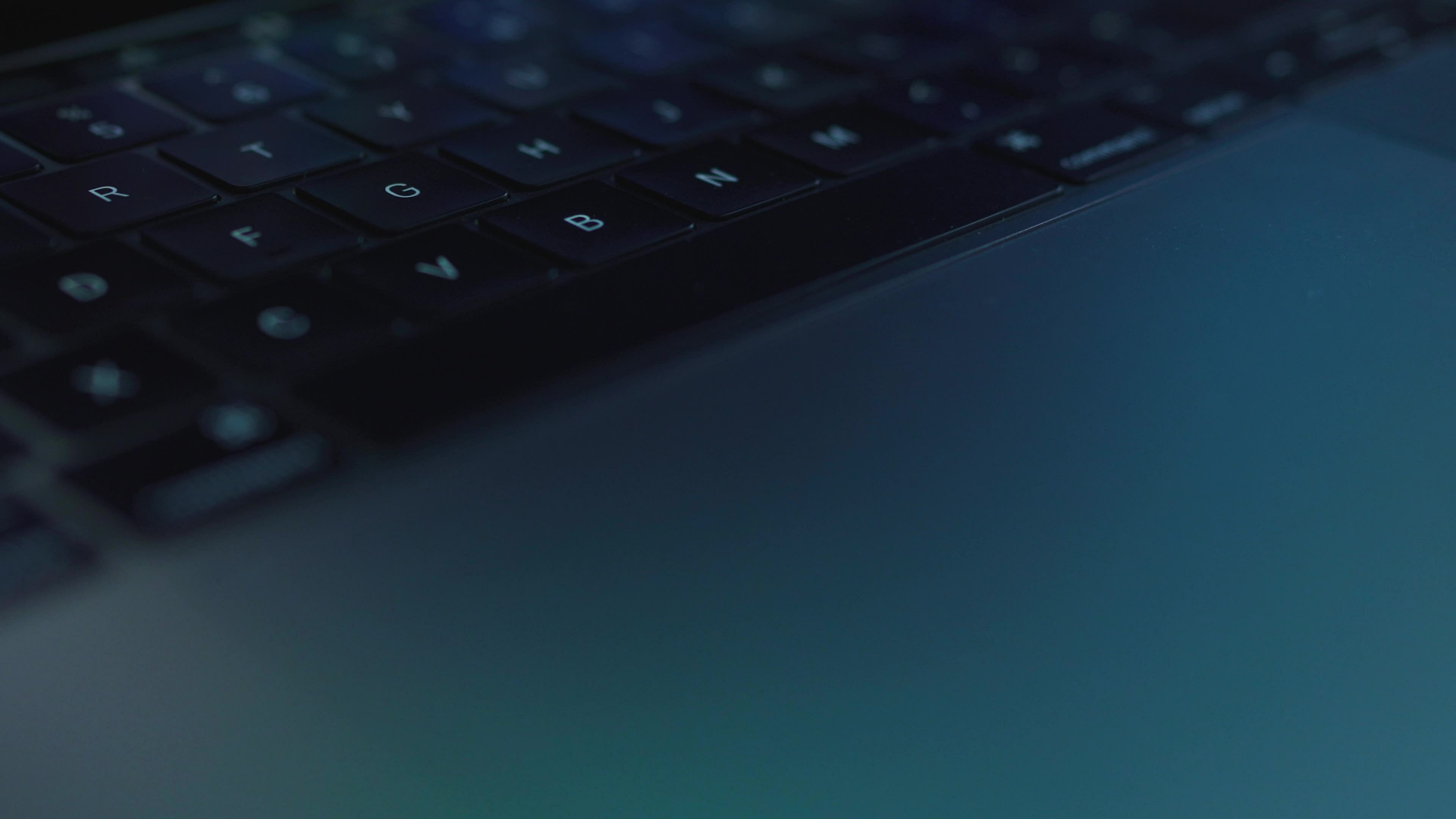 Close up laptop keyboard with multi-colored highlights on it. Very ...