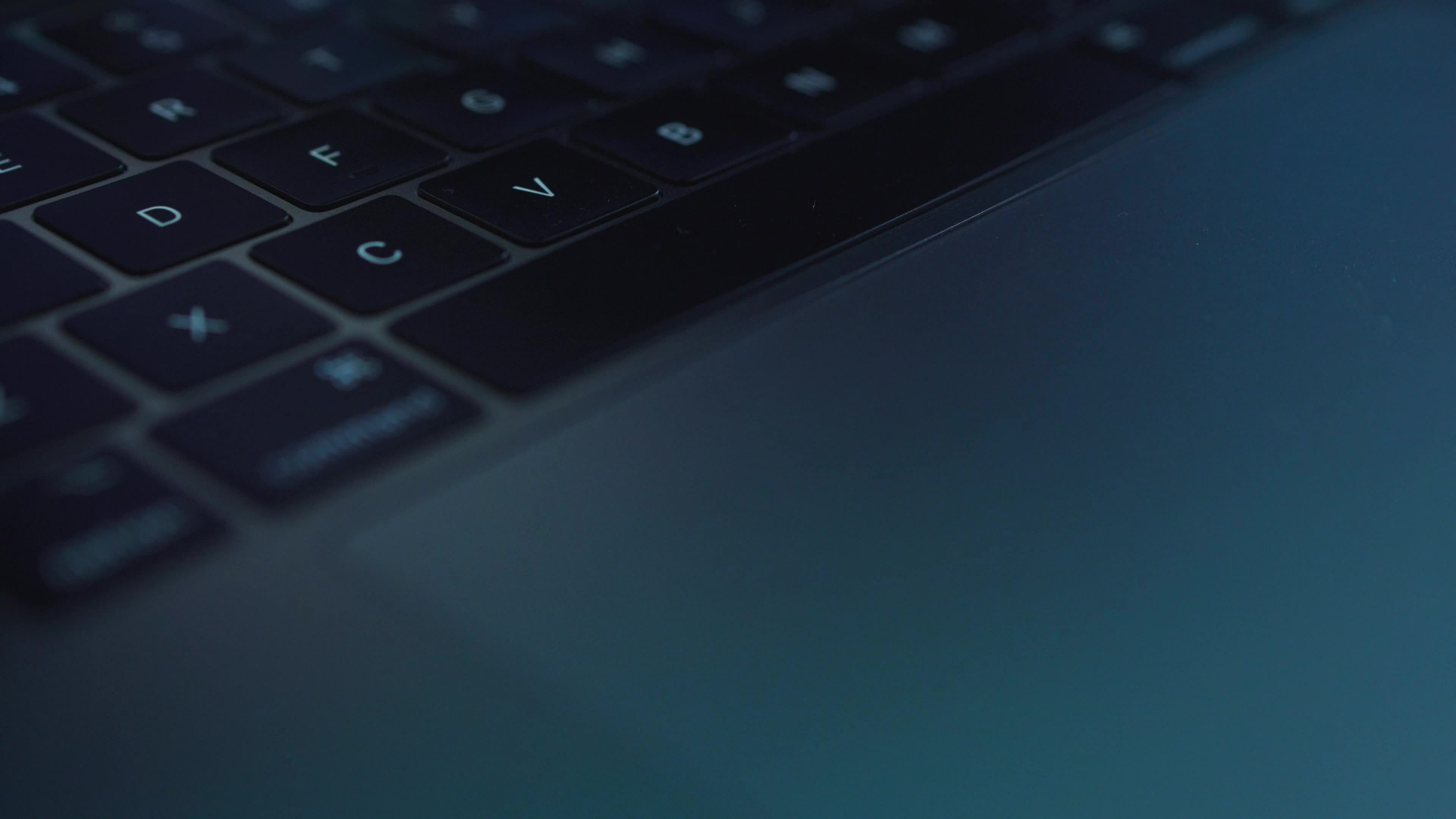 Close up laptop keyboard with multi-colored highlights on it. Very ...