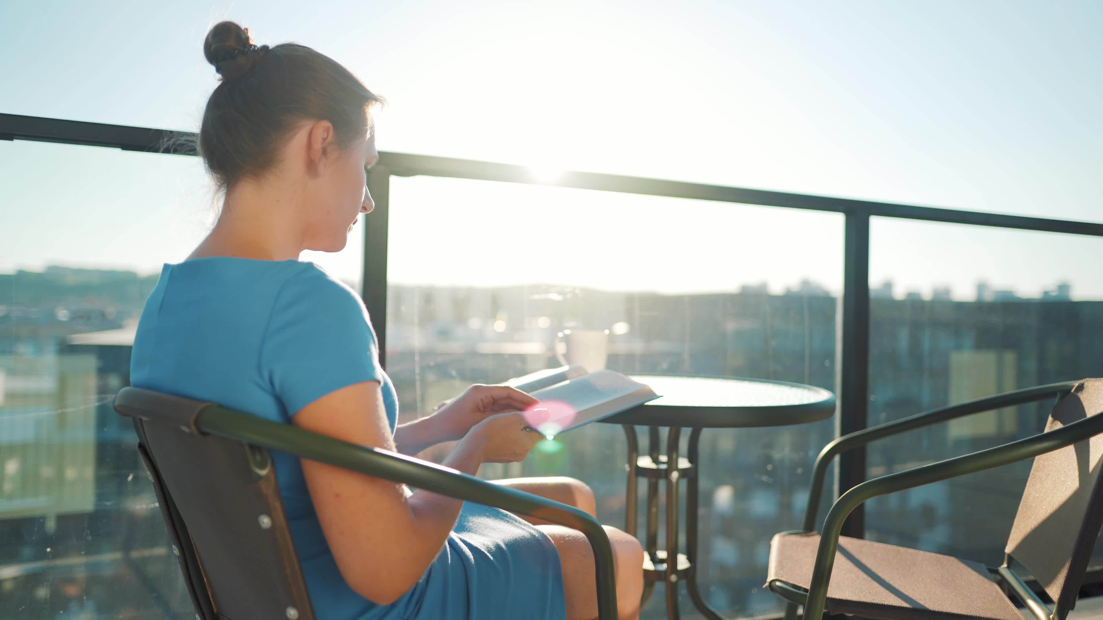 Mujer Sentado En El Balcón Y Leyendo Un Libro A Puesta De Sol 23824726
