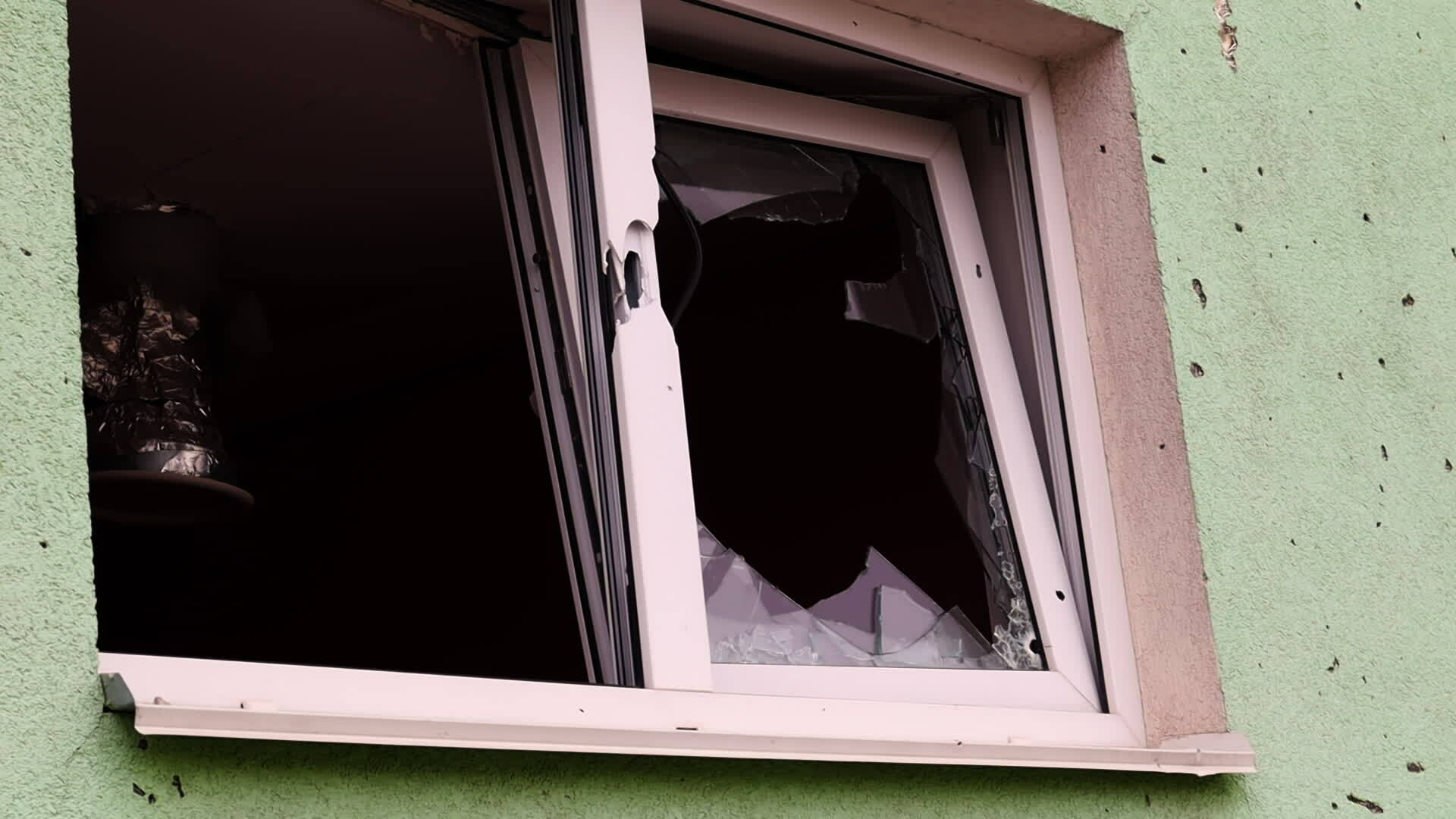 An outside view of a broken window in a building. The concept of street crime, vandalism ...