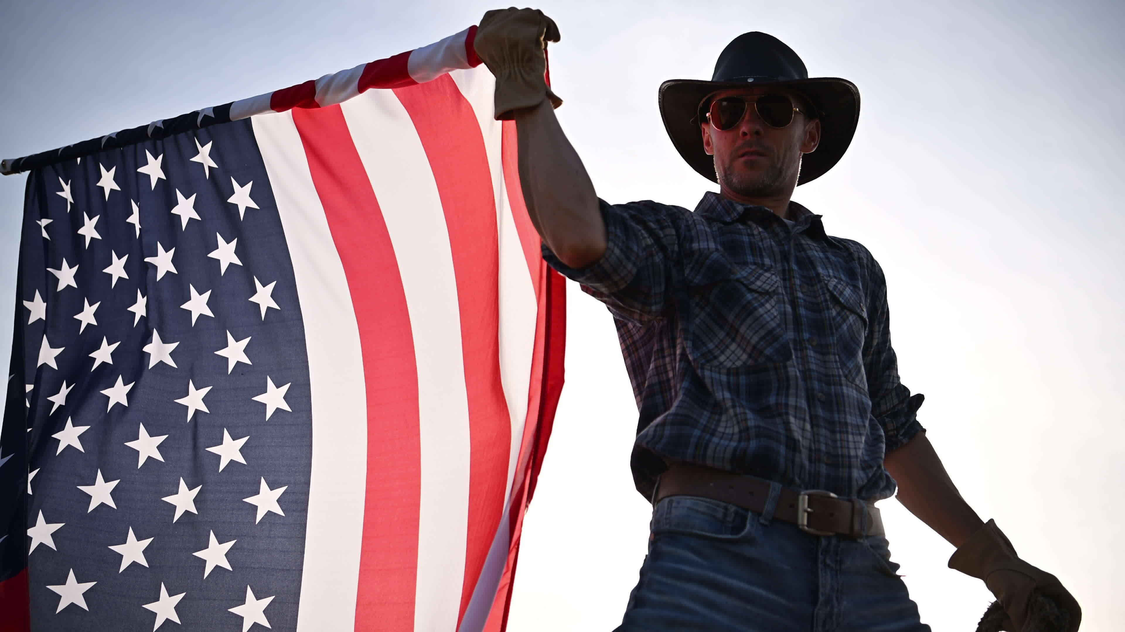 Caucasian Proud American Cowboy Waving United States Flag 24672010 caucasian-proud-american-cowboy-waving-united-states-flag-24672010
