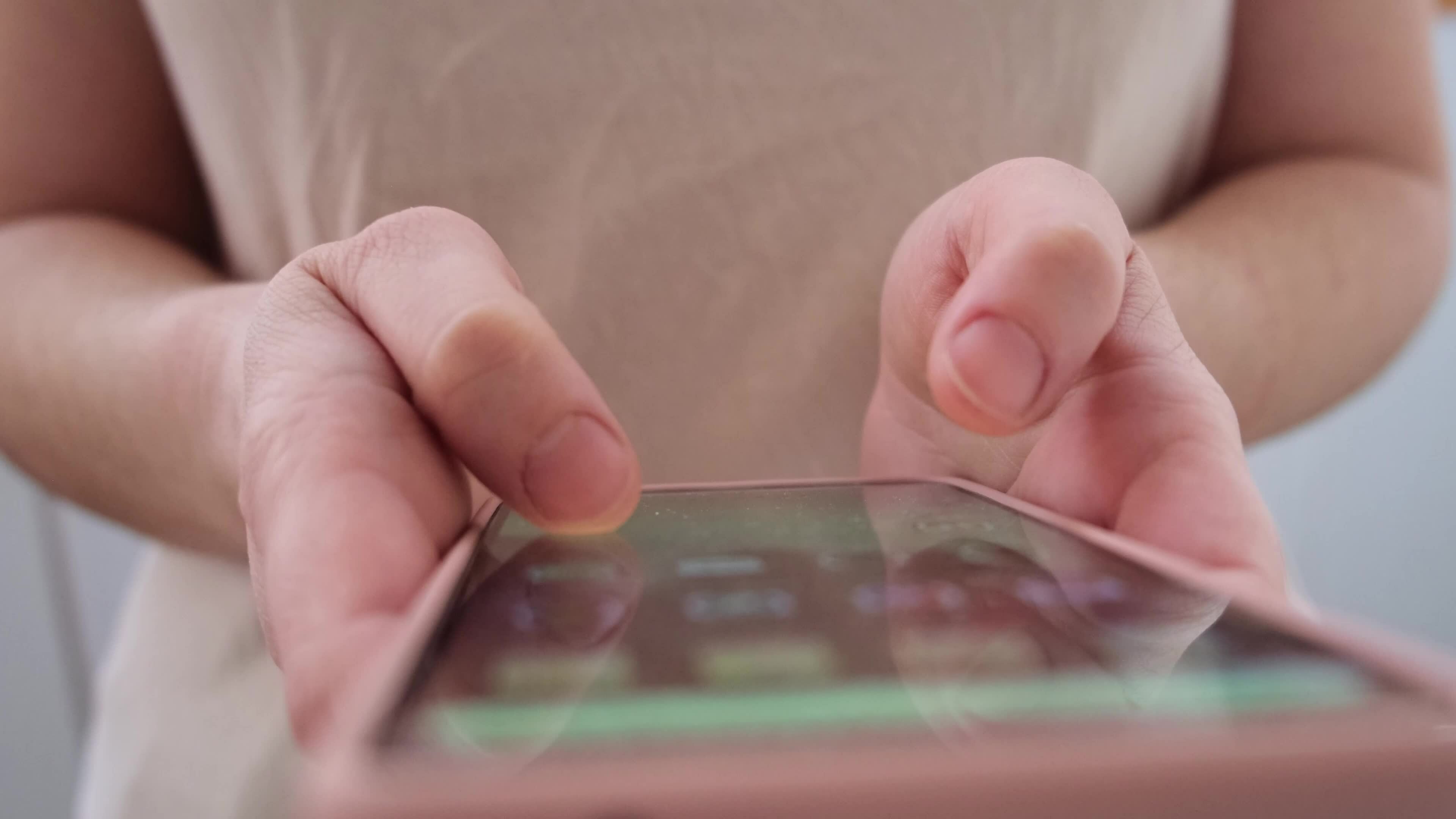 Woman hand holding cell phone touch screen typing scroll page using app. Smartphone mobile phone ...