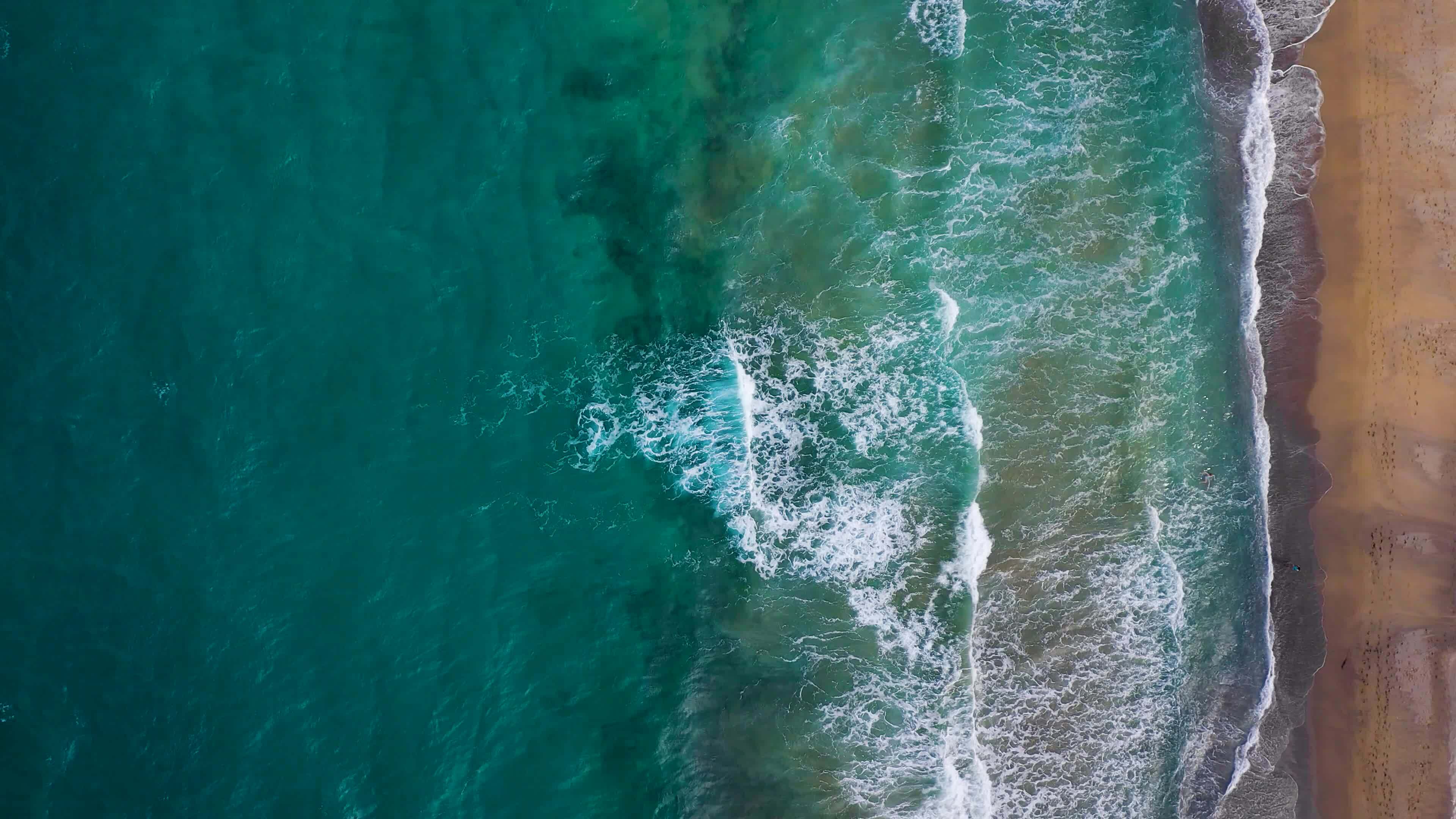 Aerial view of the Mediterranean coast, waves reach the deserted sandy ...